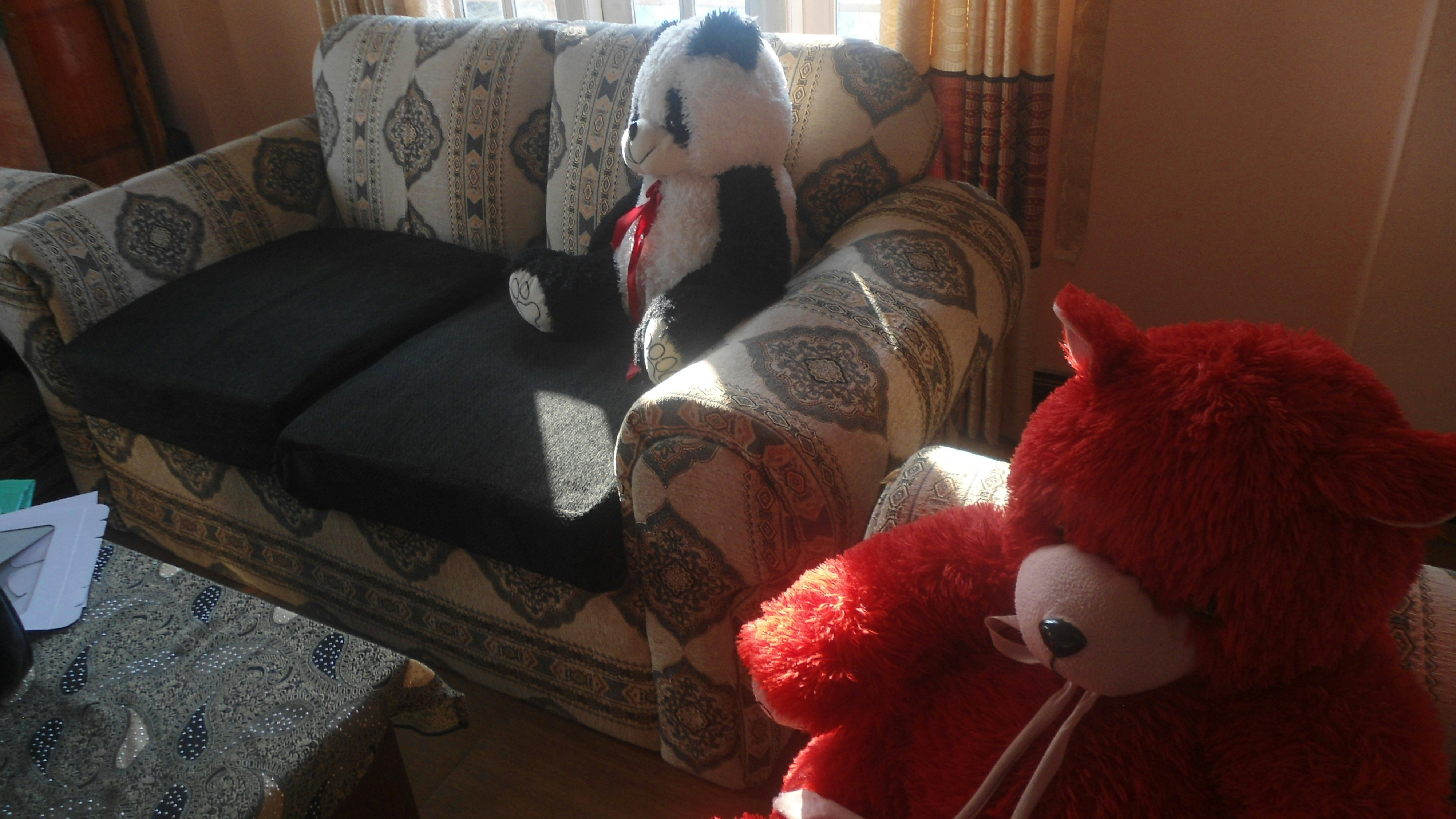Two stuffed animals on a couch.