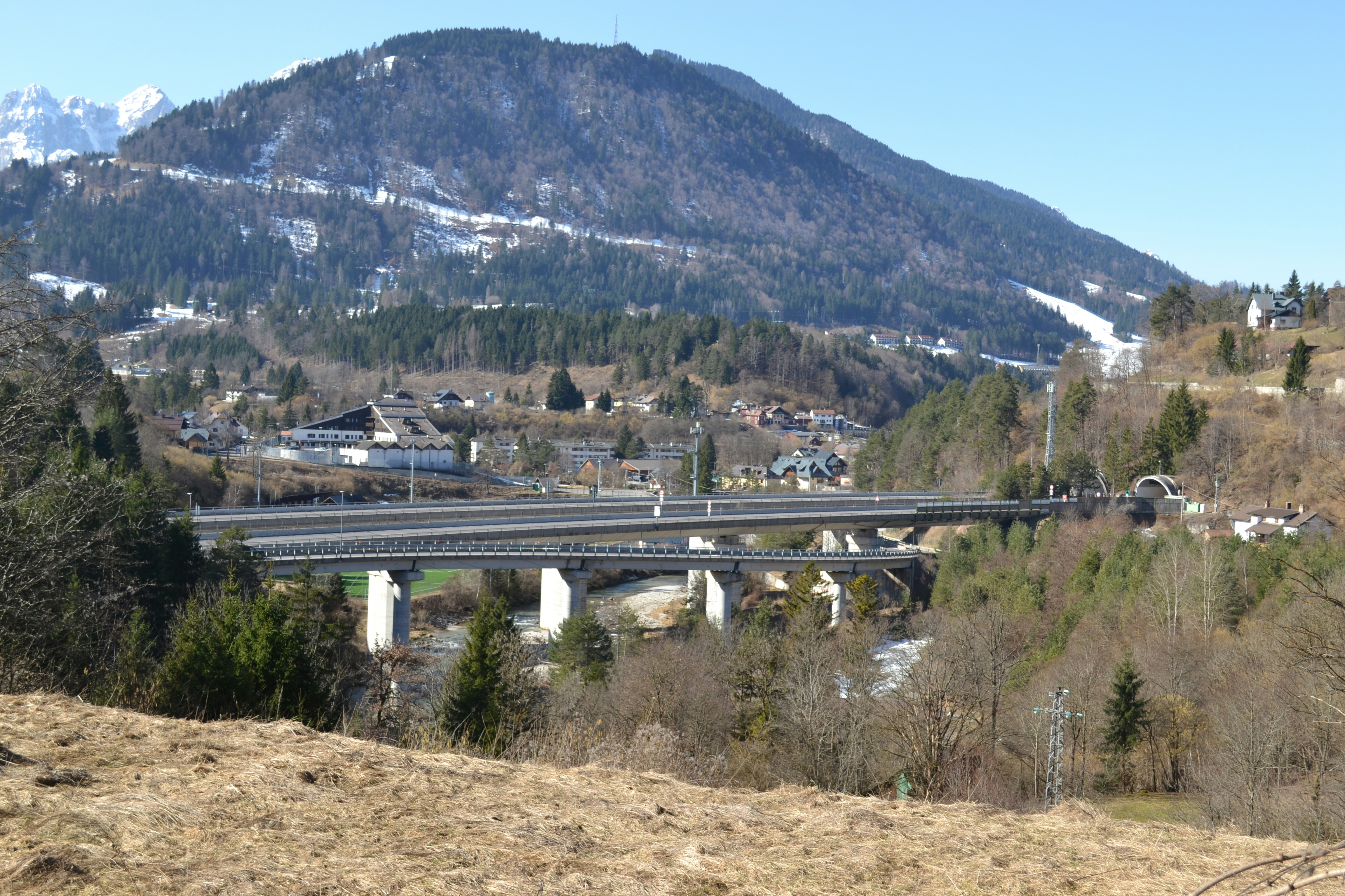Bridge over hillside village as mountains loom