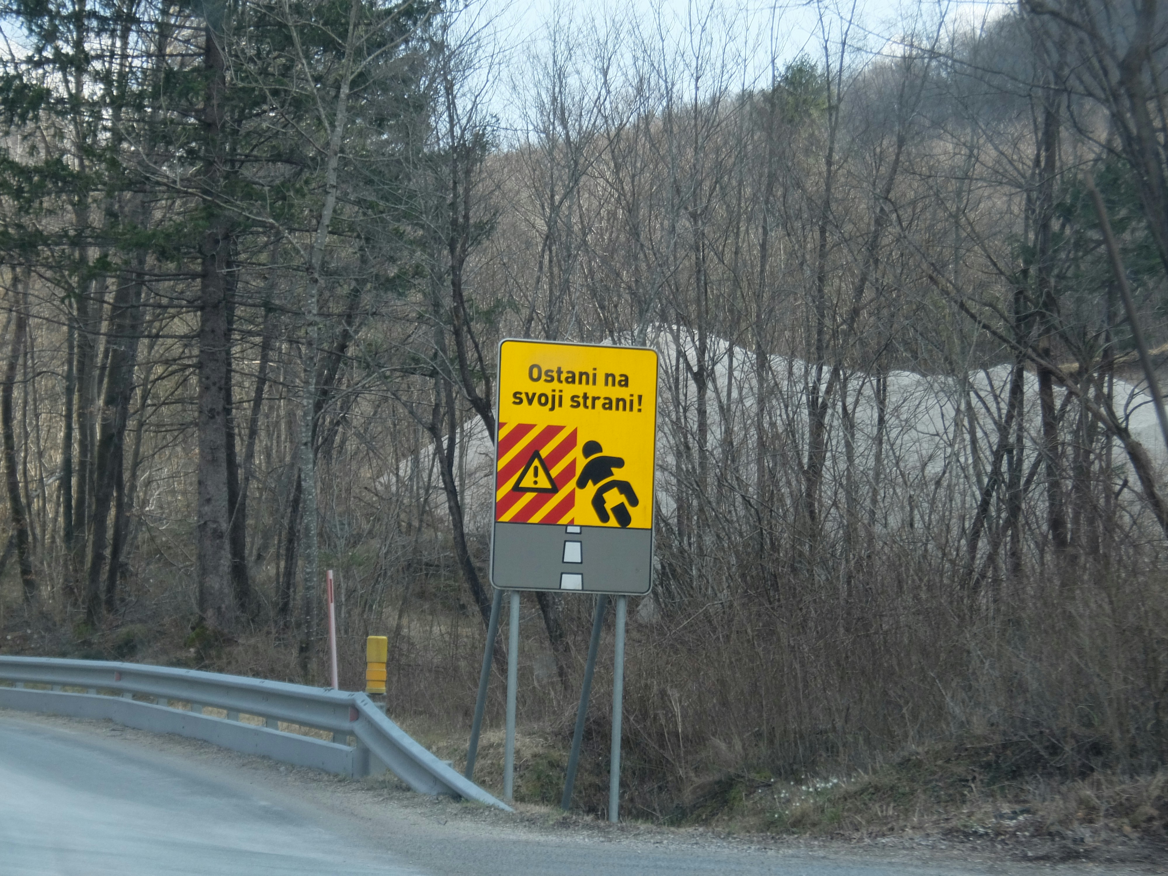 Road sign with warning for slippery road and motorcycle symbol