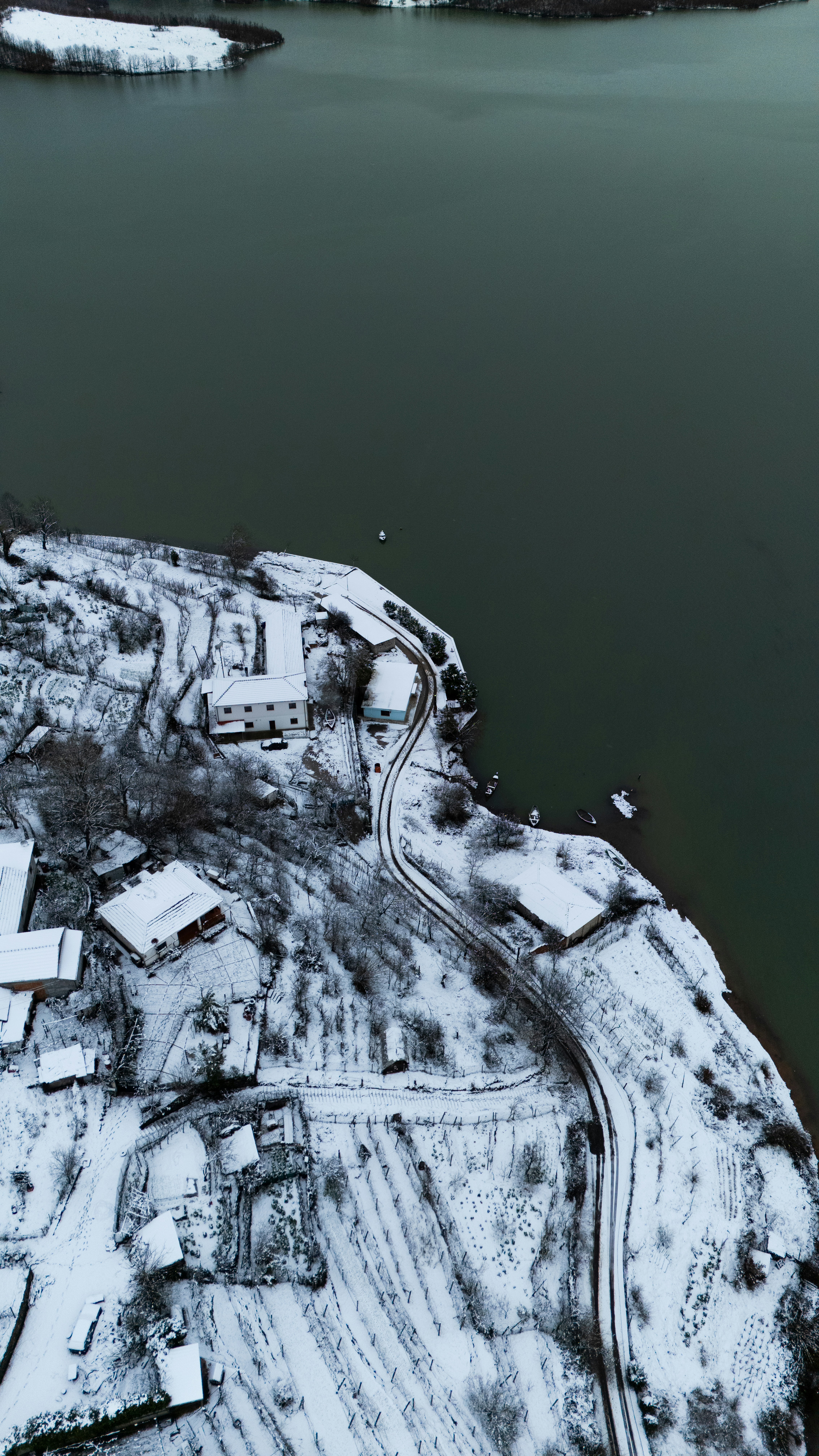 Snowbound Riverside: Aerial Quiet Over a Frozen Shore