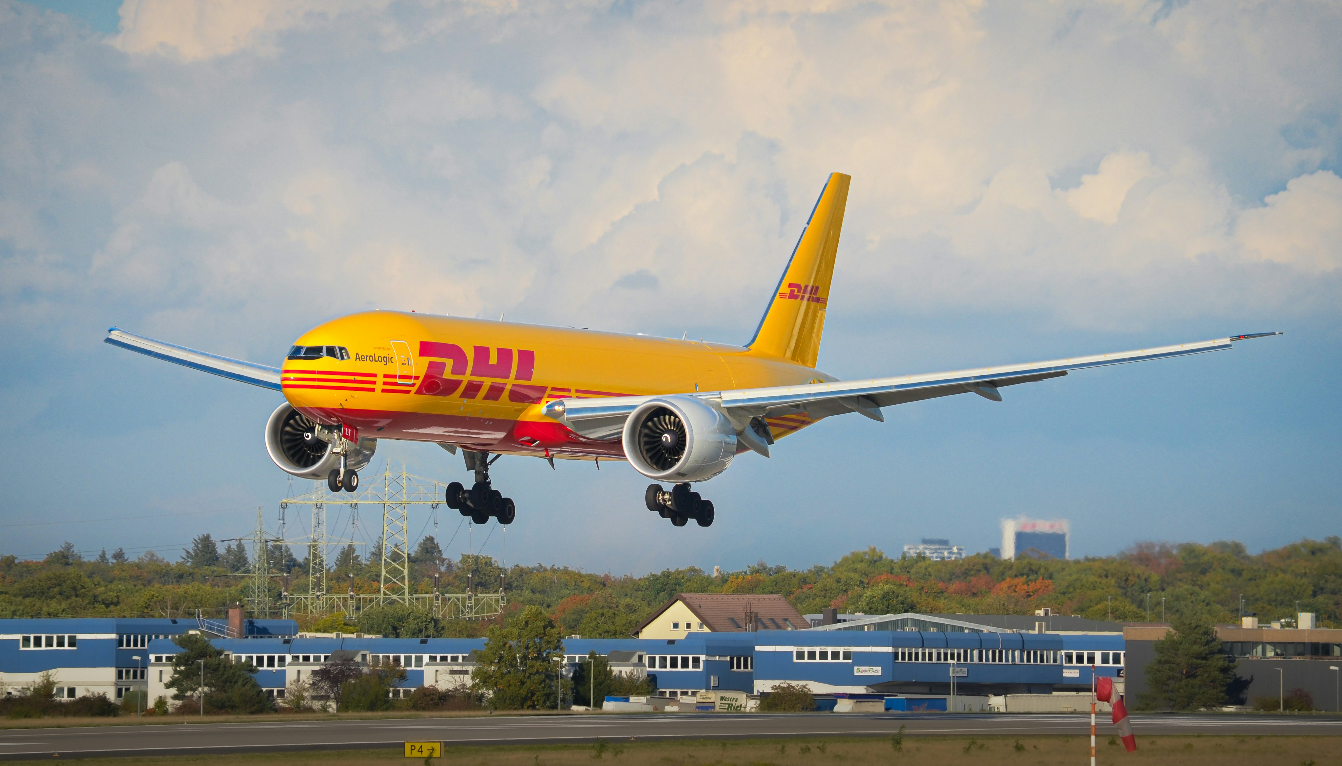 A dhl cargo plane lands on a runway.