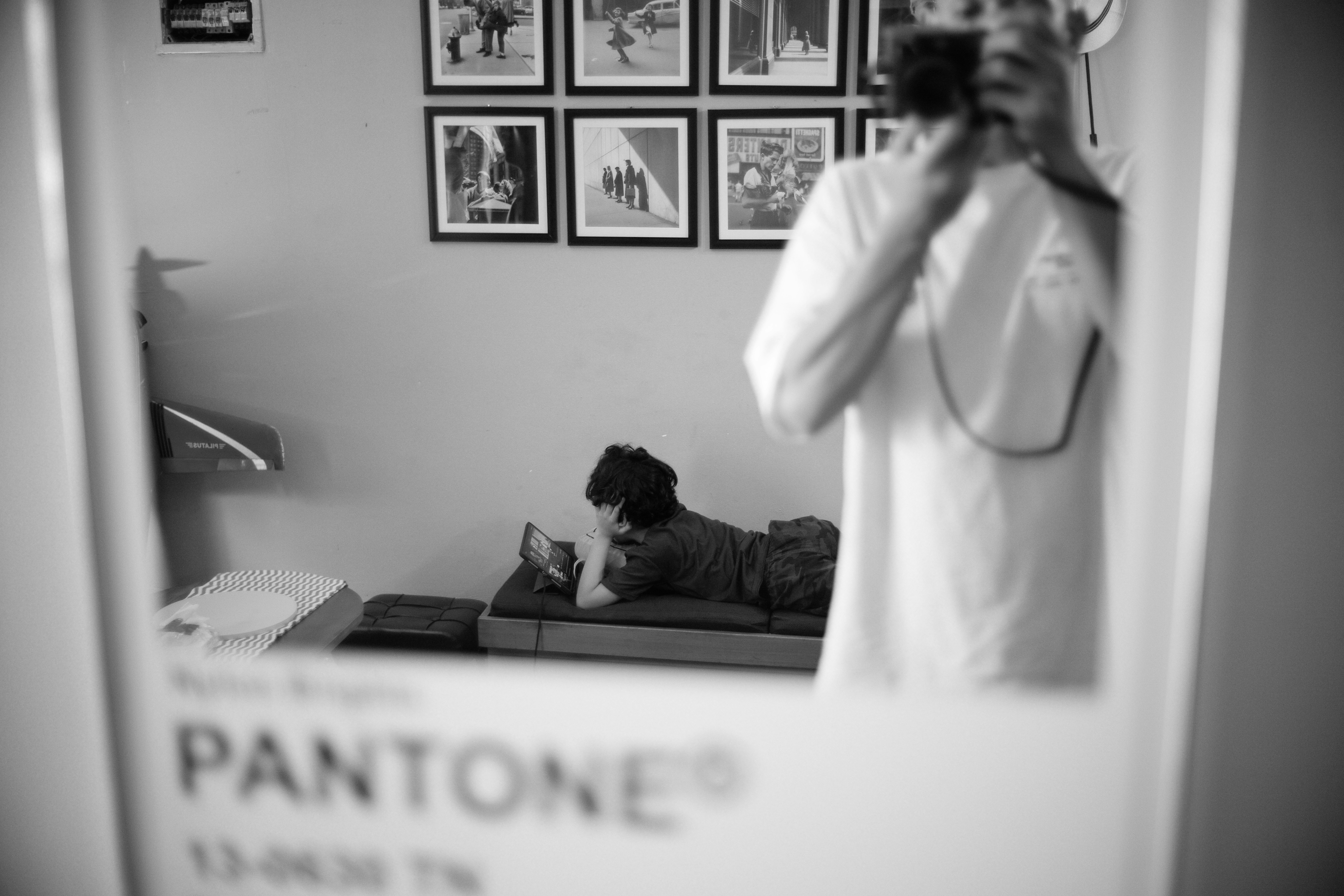 Person taking a selfie in a room with framed pictures.