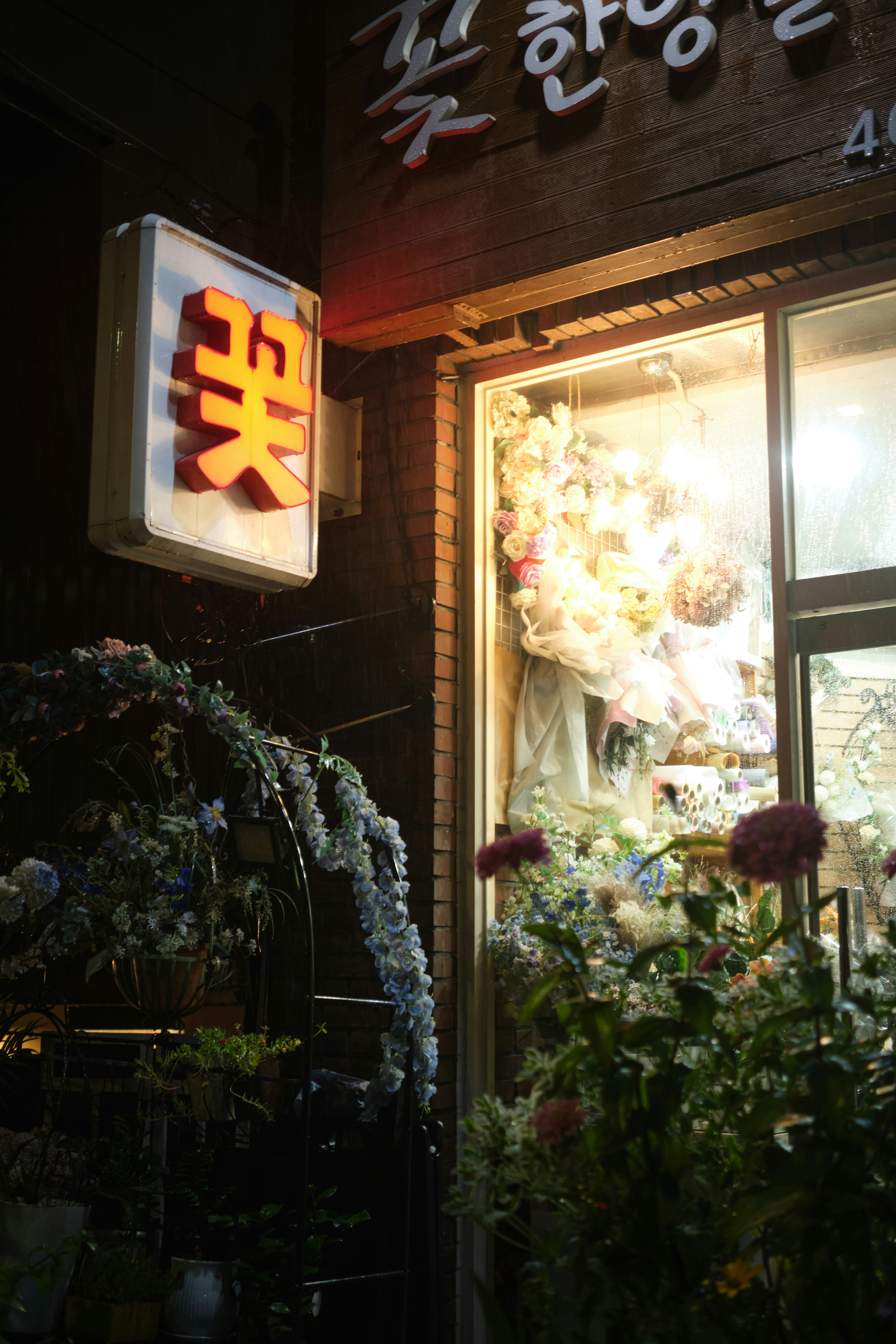 Neon Sign and Floral Shopfront Framed by Night Bloom