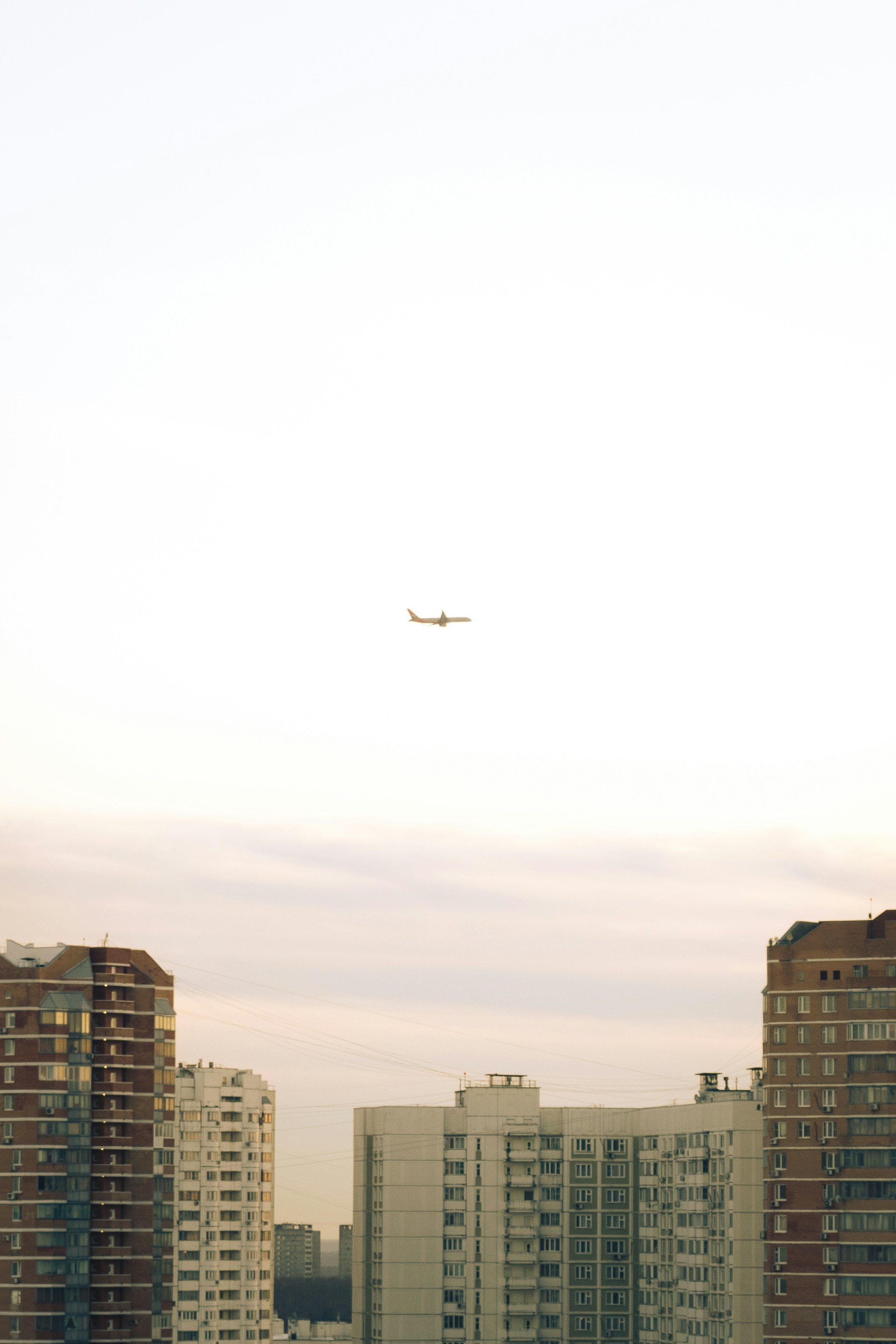 Plane Above the Quiet Cityscape at Dusk
