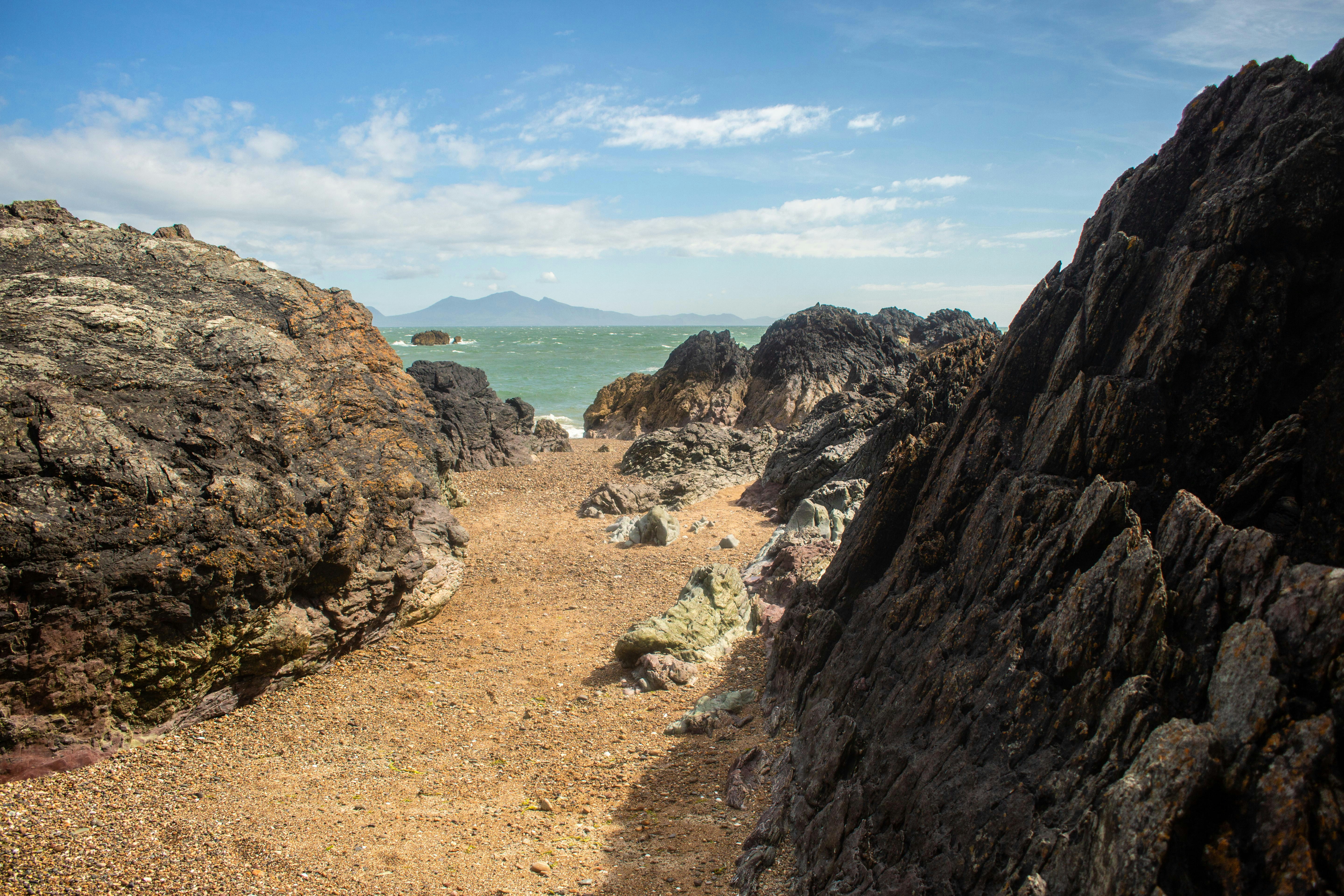 Rocky Path to the Sea: A Sunlit Corridor Between Coastal Formations