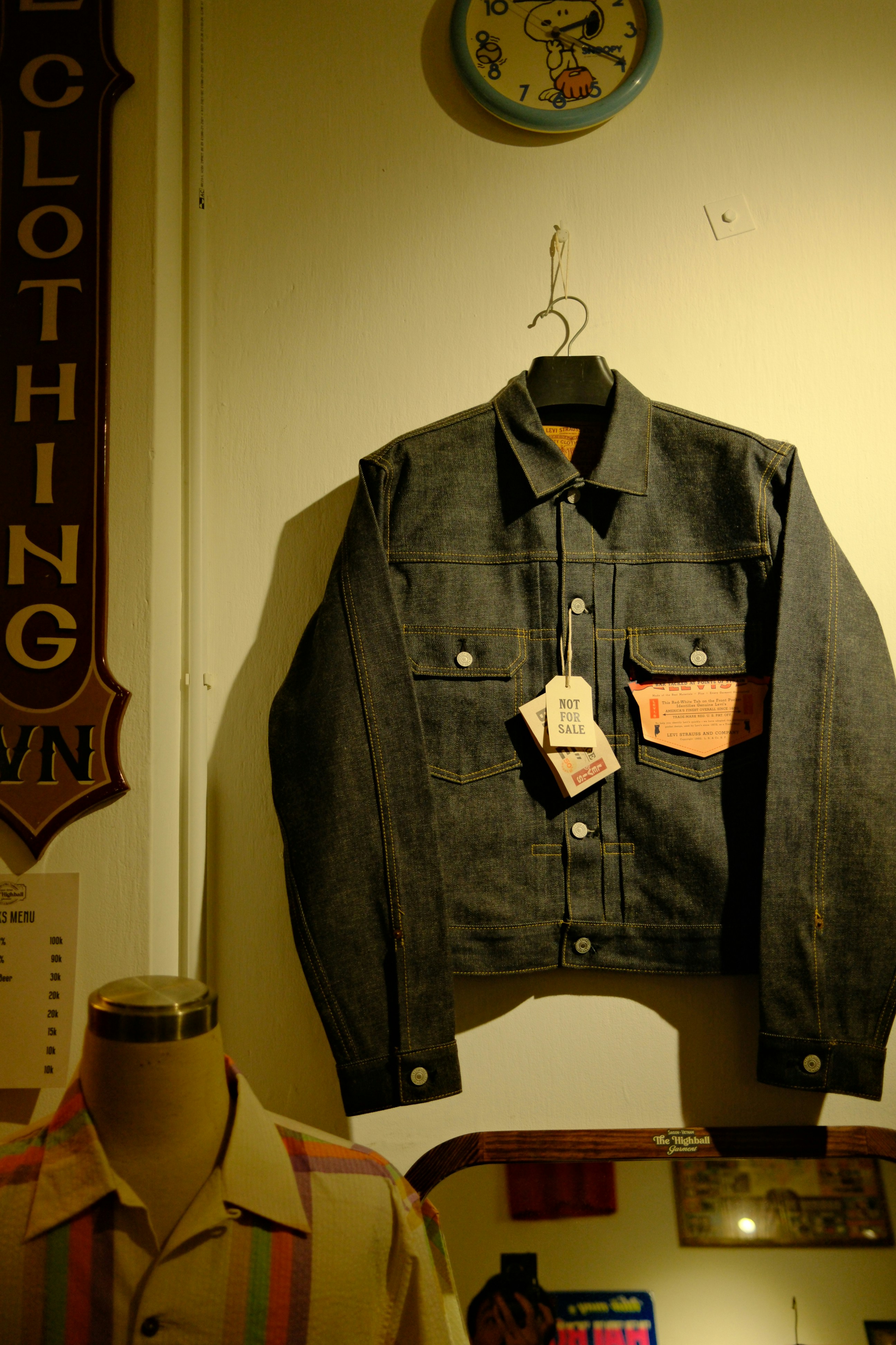 Denim on Display: A Vintage Jacket Hangs Under Warm Shop Lighting