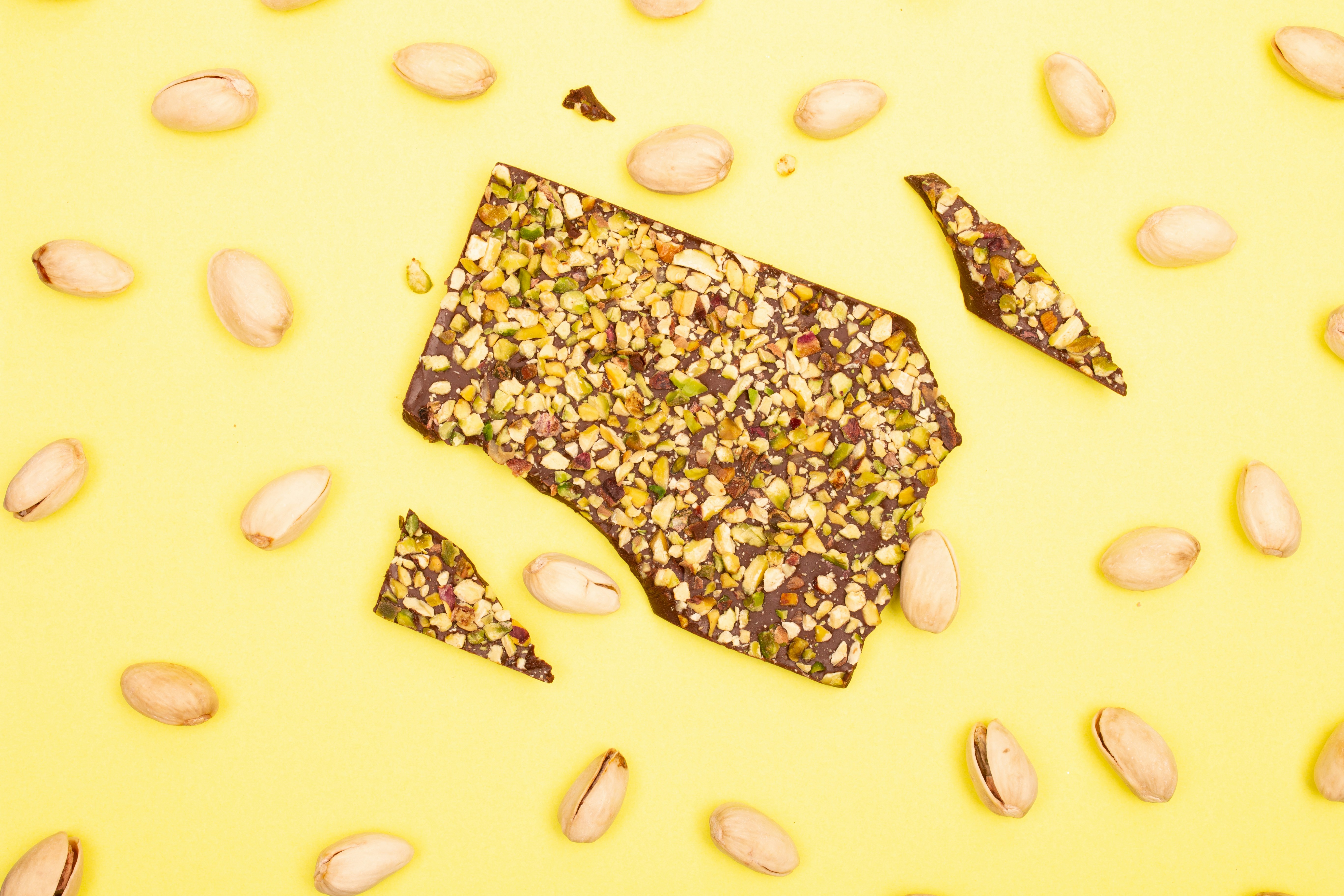 Chopped chocolate bark scattered over a sunny yellow backdrop
