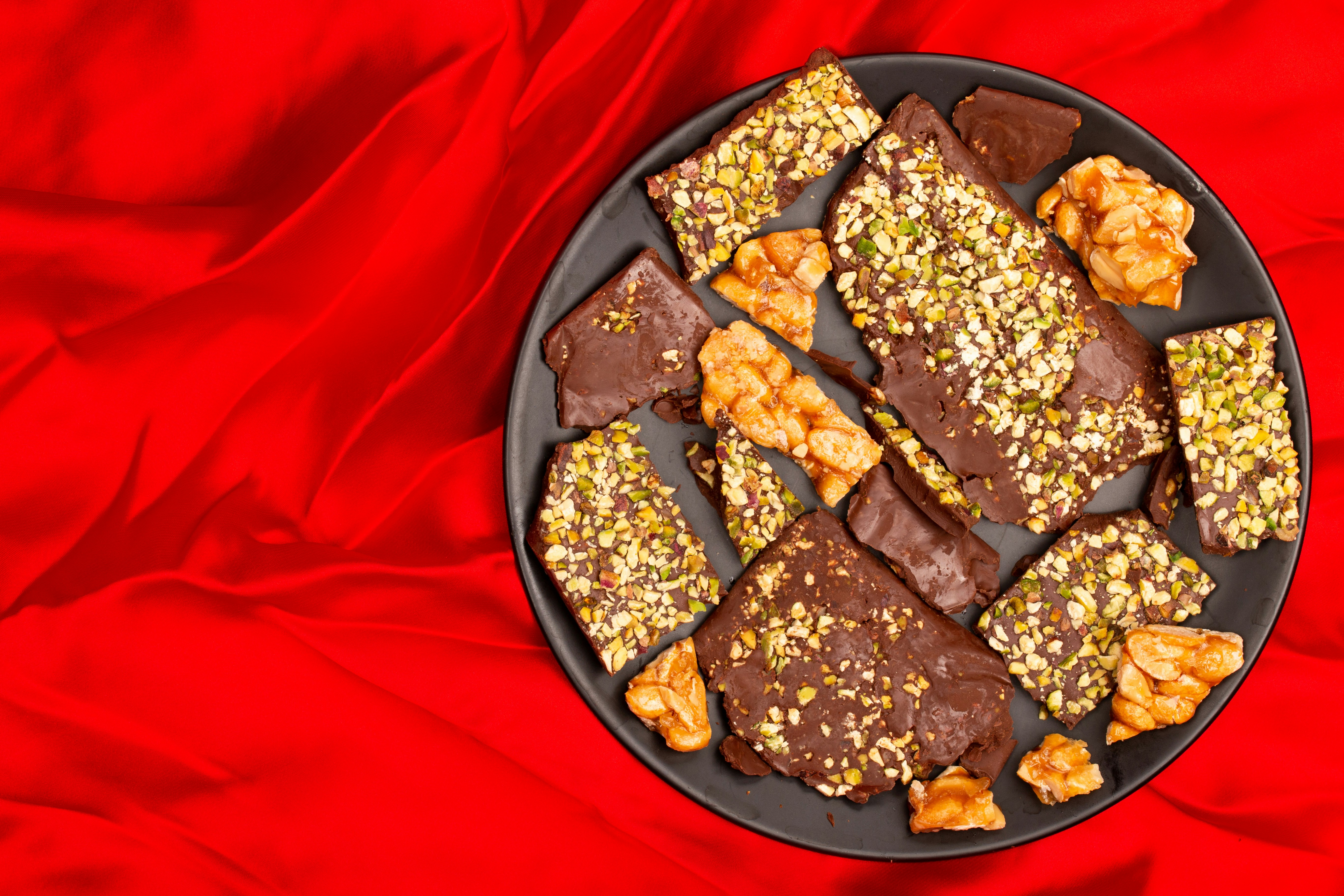 Sweet Constellation: Assorted Nut-Topped Chocolate Bars on a Red Velvet Spread
