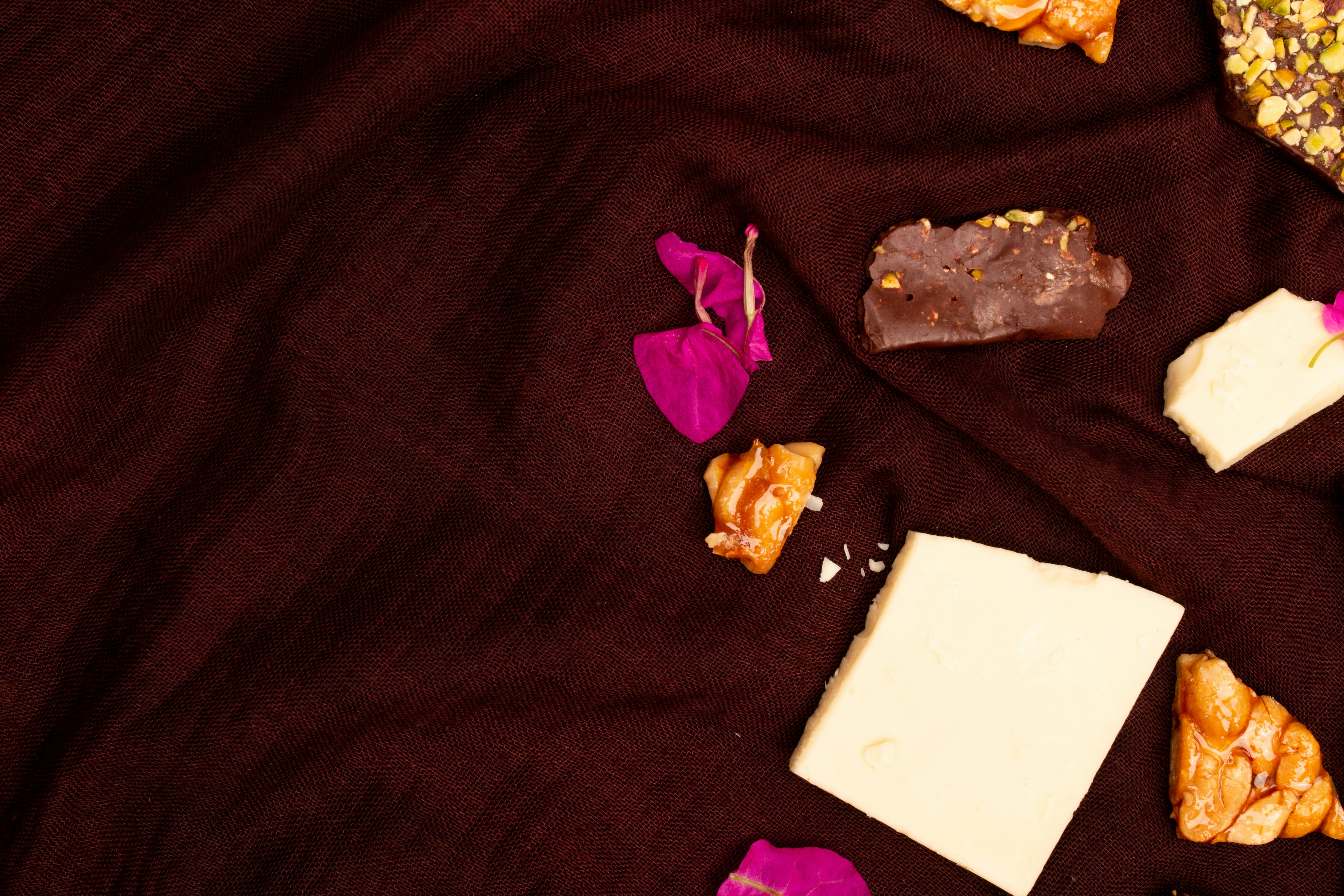 Crumbled chocolate and cocoa butter fragments on a deep burgundy cloth