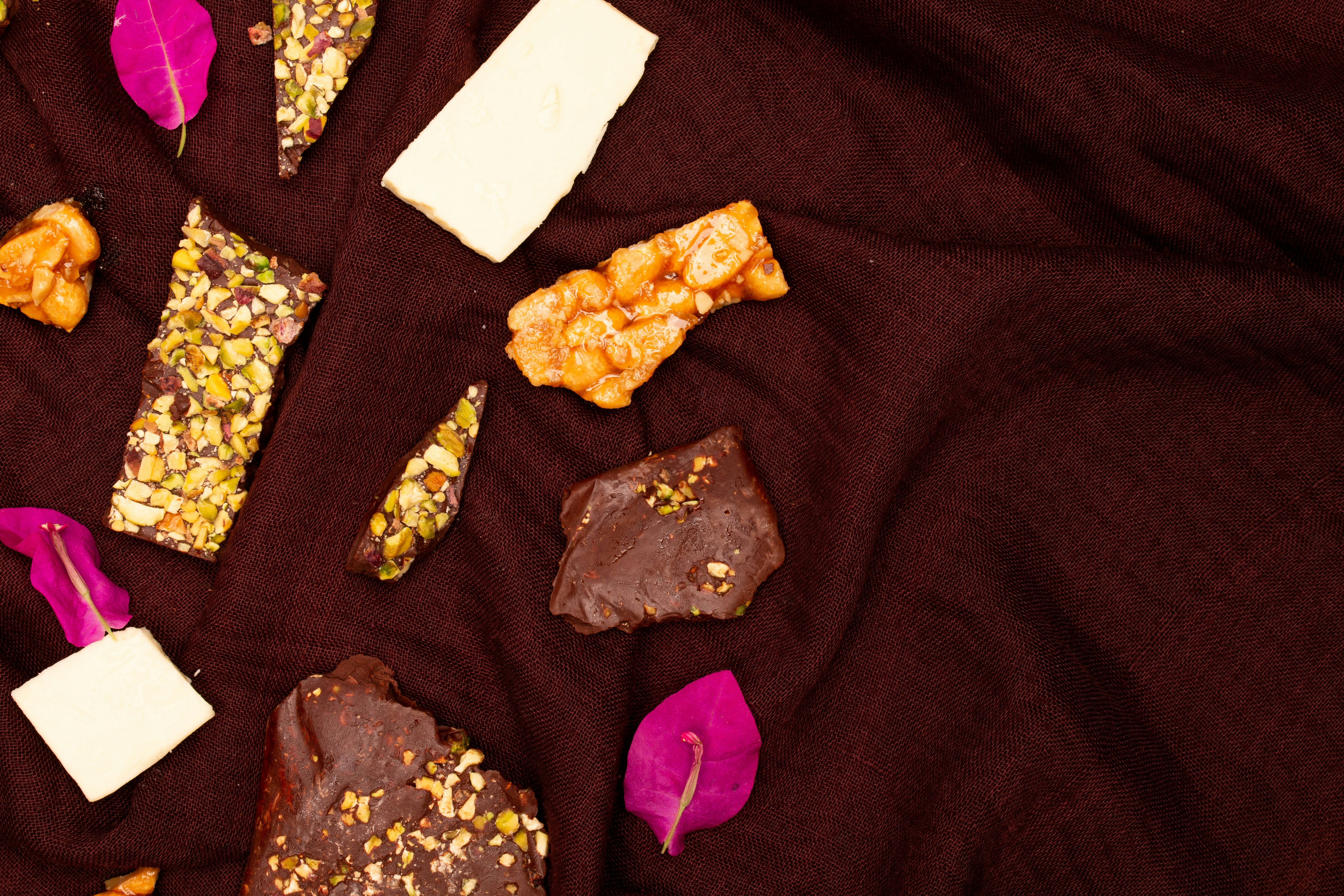 Chocolates on a Deep Garnet Cloth: Fragile Treats and Colorful Accents
