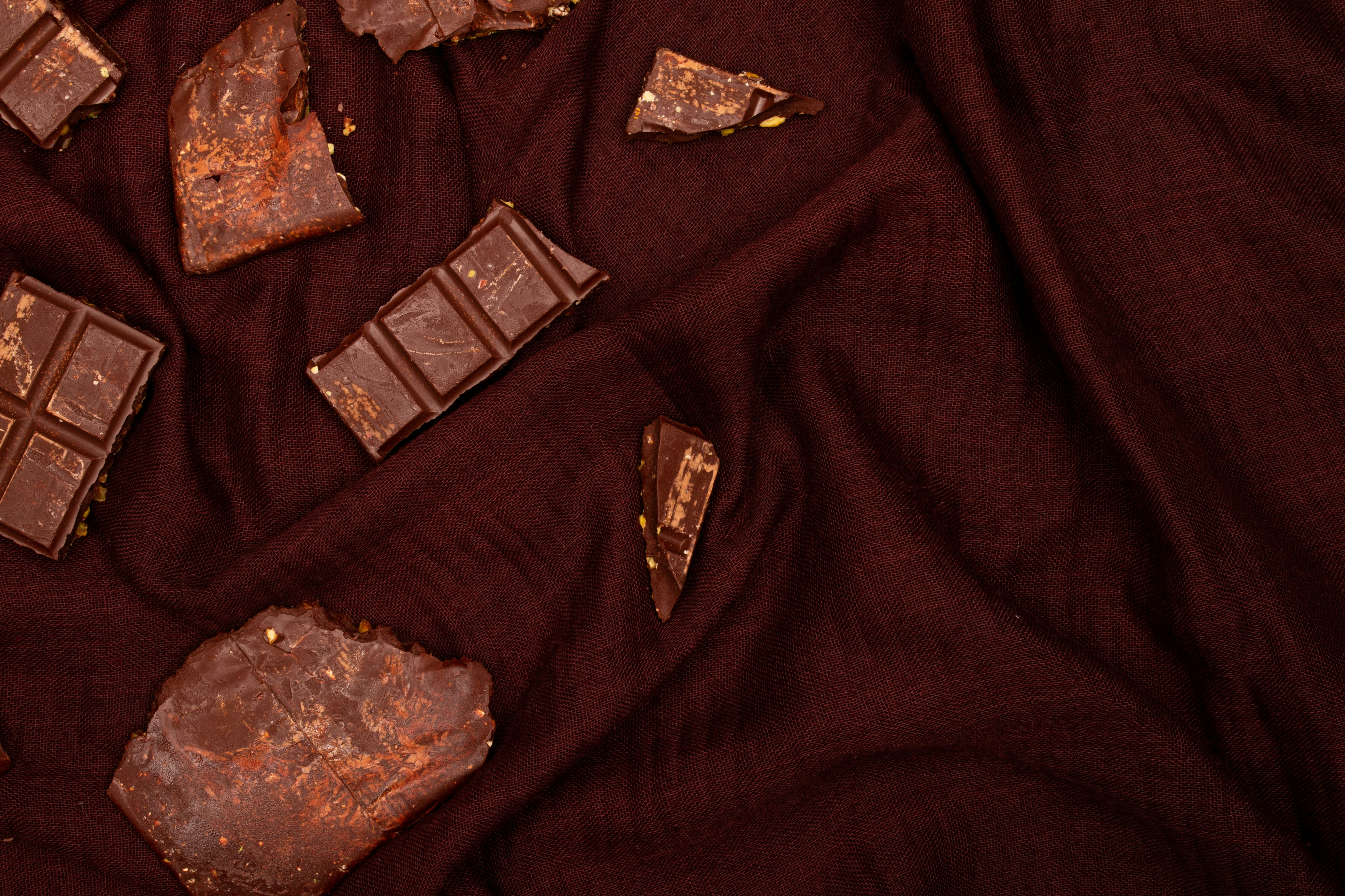 Bittersweet Riches: Chocolate Fragments on Velvet Red