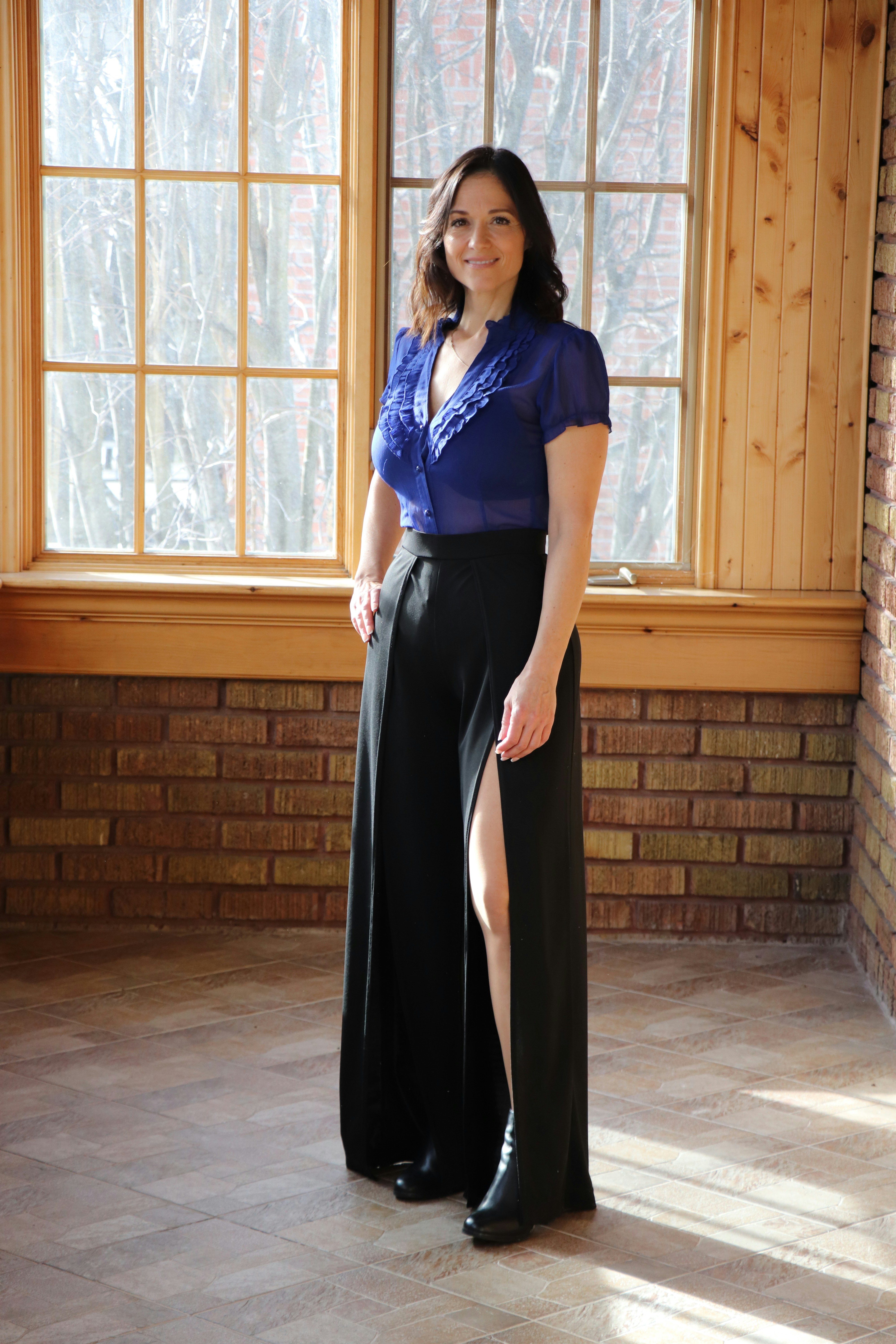 Azure blouse, ebony slit: a poised portrait by sunlit windows