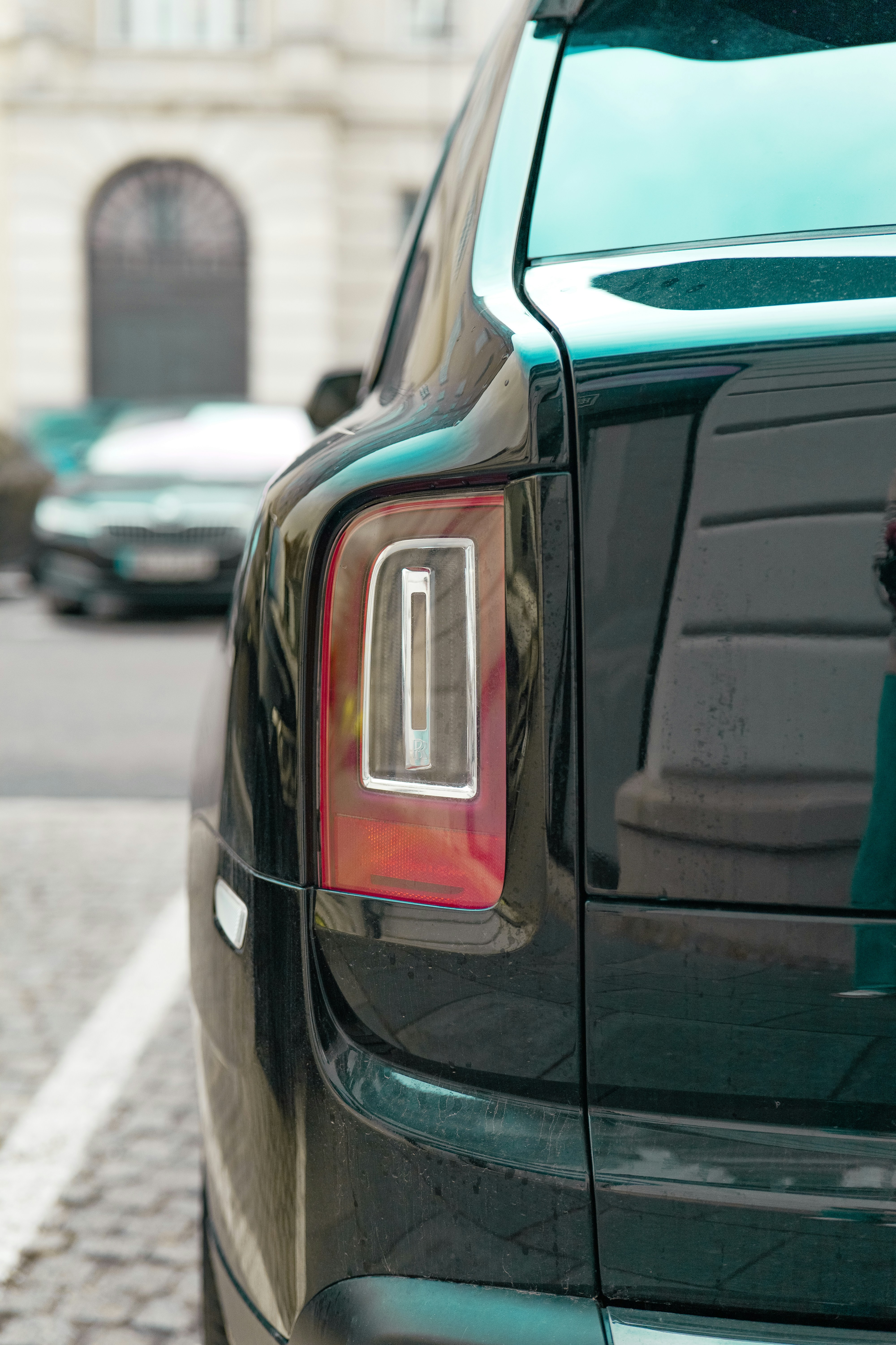 Tail Light Portrait of a Black SUV in an Urban Square
