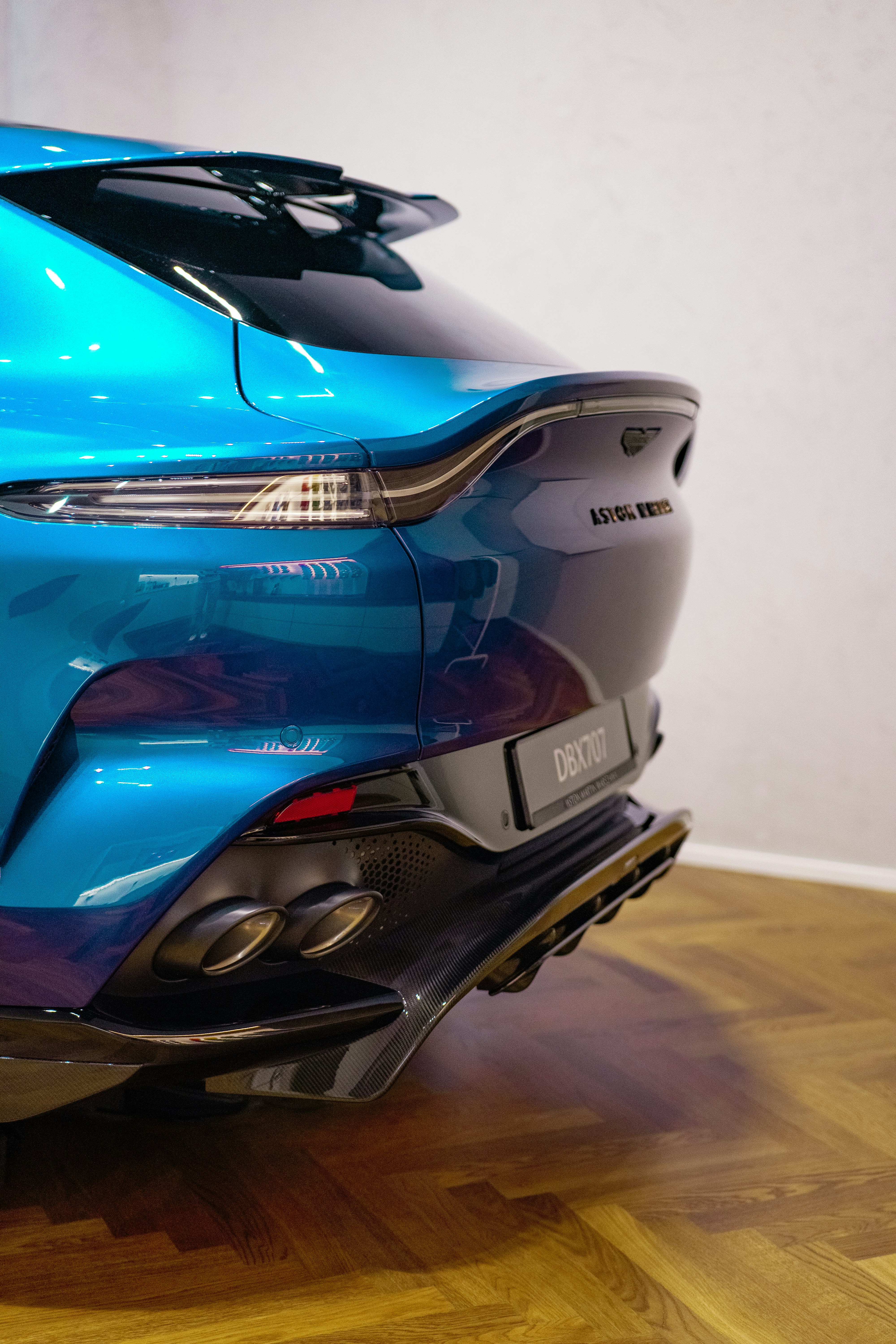 Blue hypercar silhouette: rear quarter and aero details in a showroom