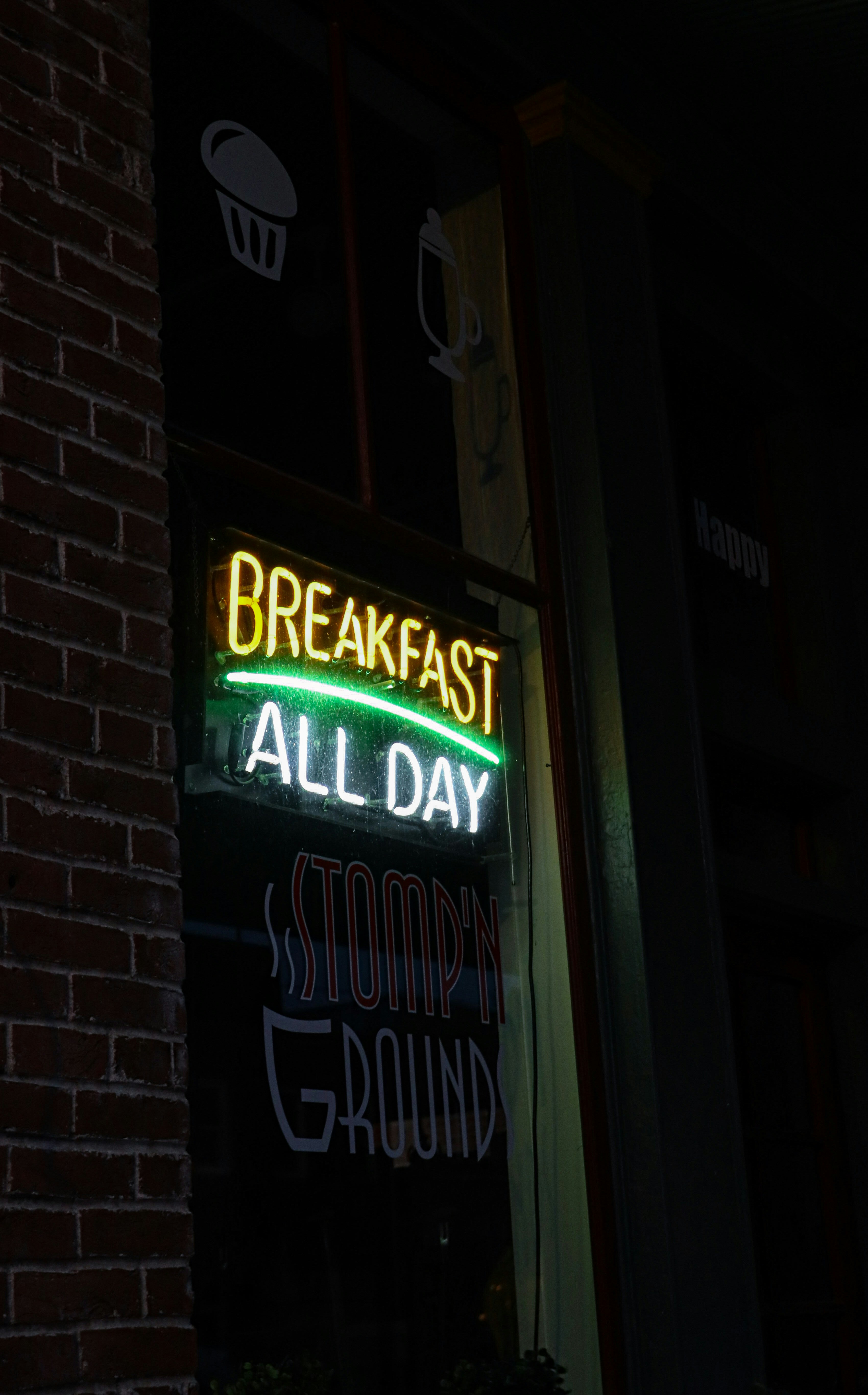 Neon Breakfast Sign Casts a Nighttime Glow Across a Brick Front