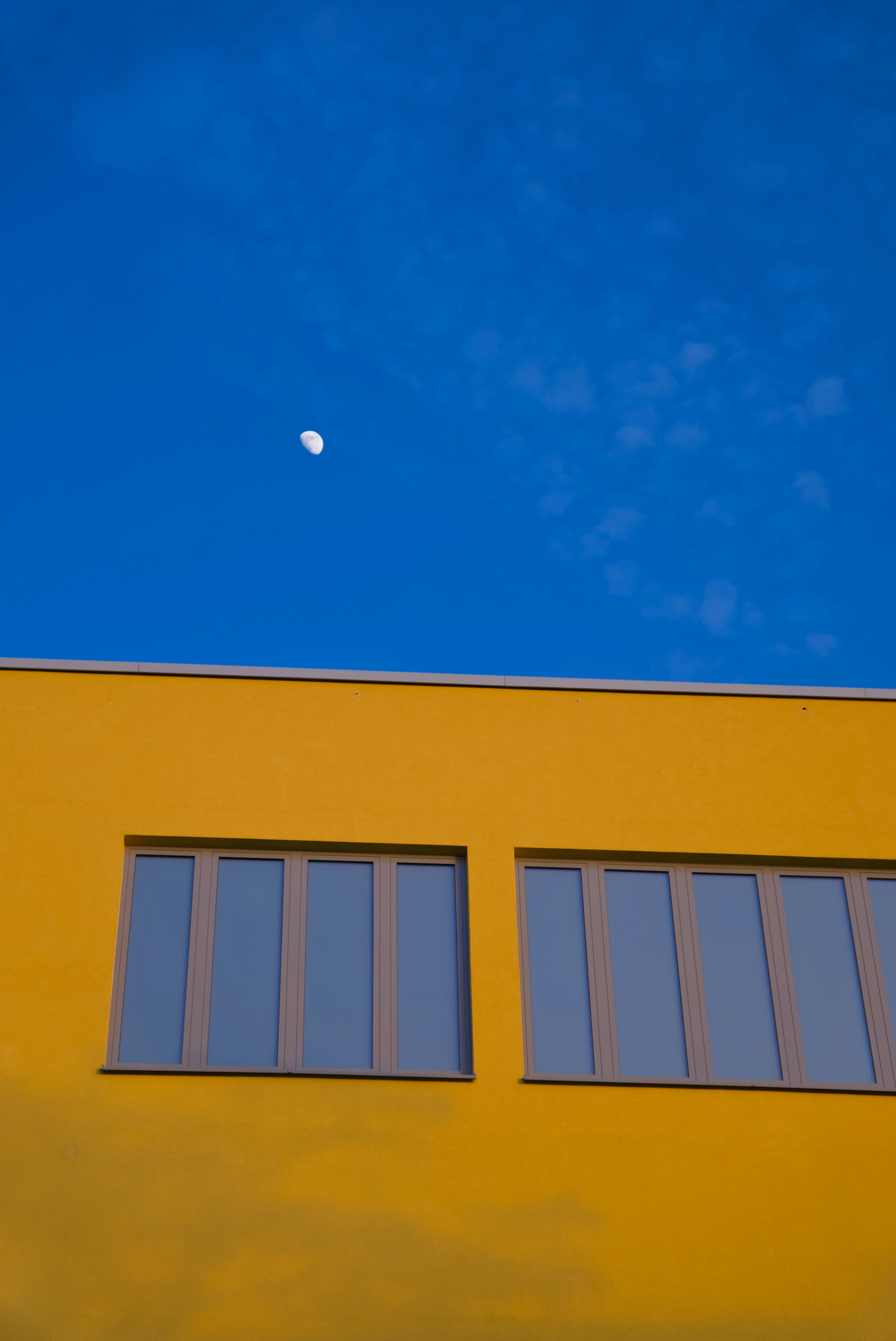 Moon over a Sunlit Factory Facade