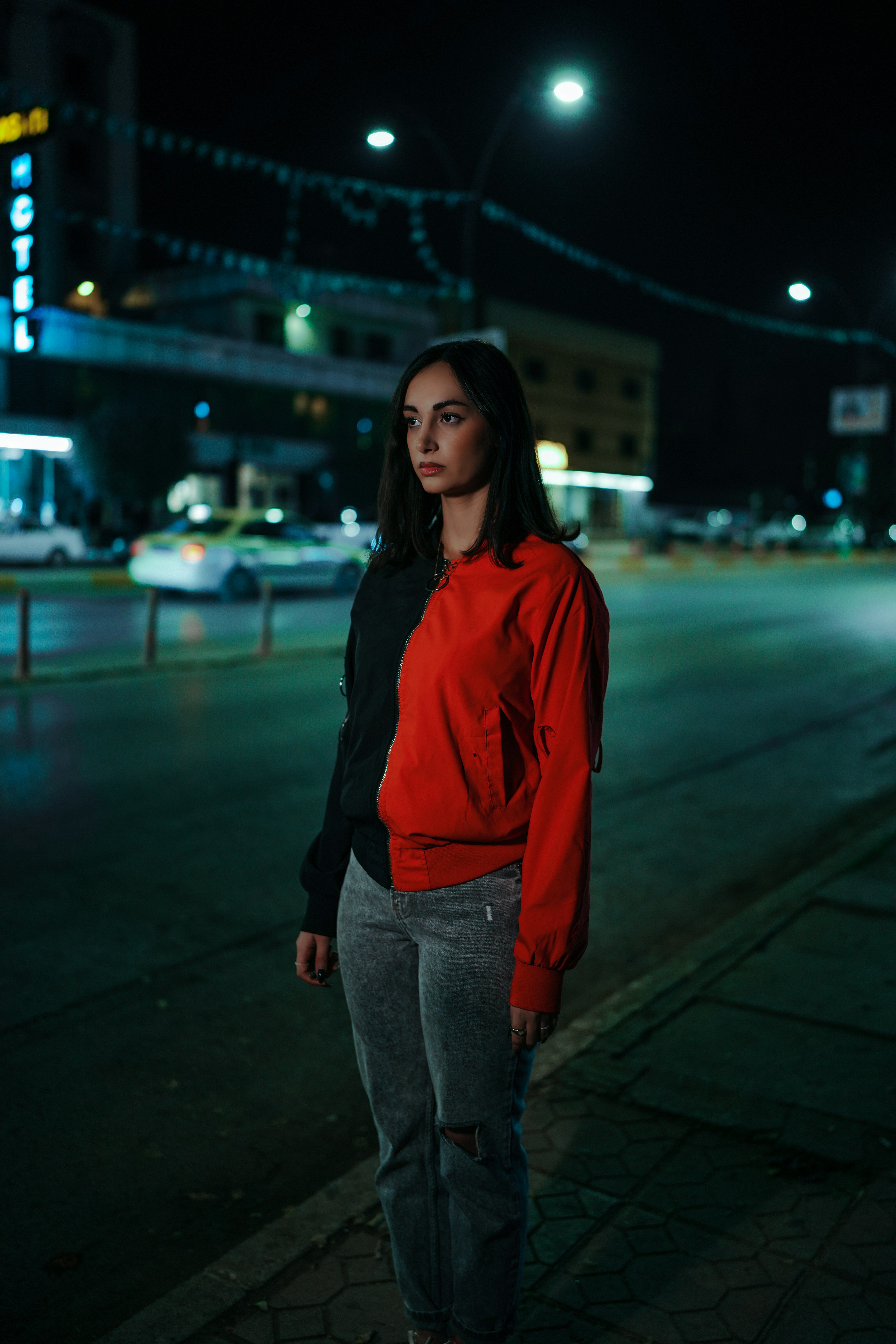Midnight Neon: A Woman in Two-Toned Jacket Under City Lights