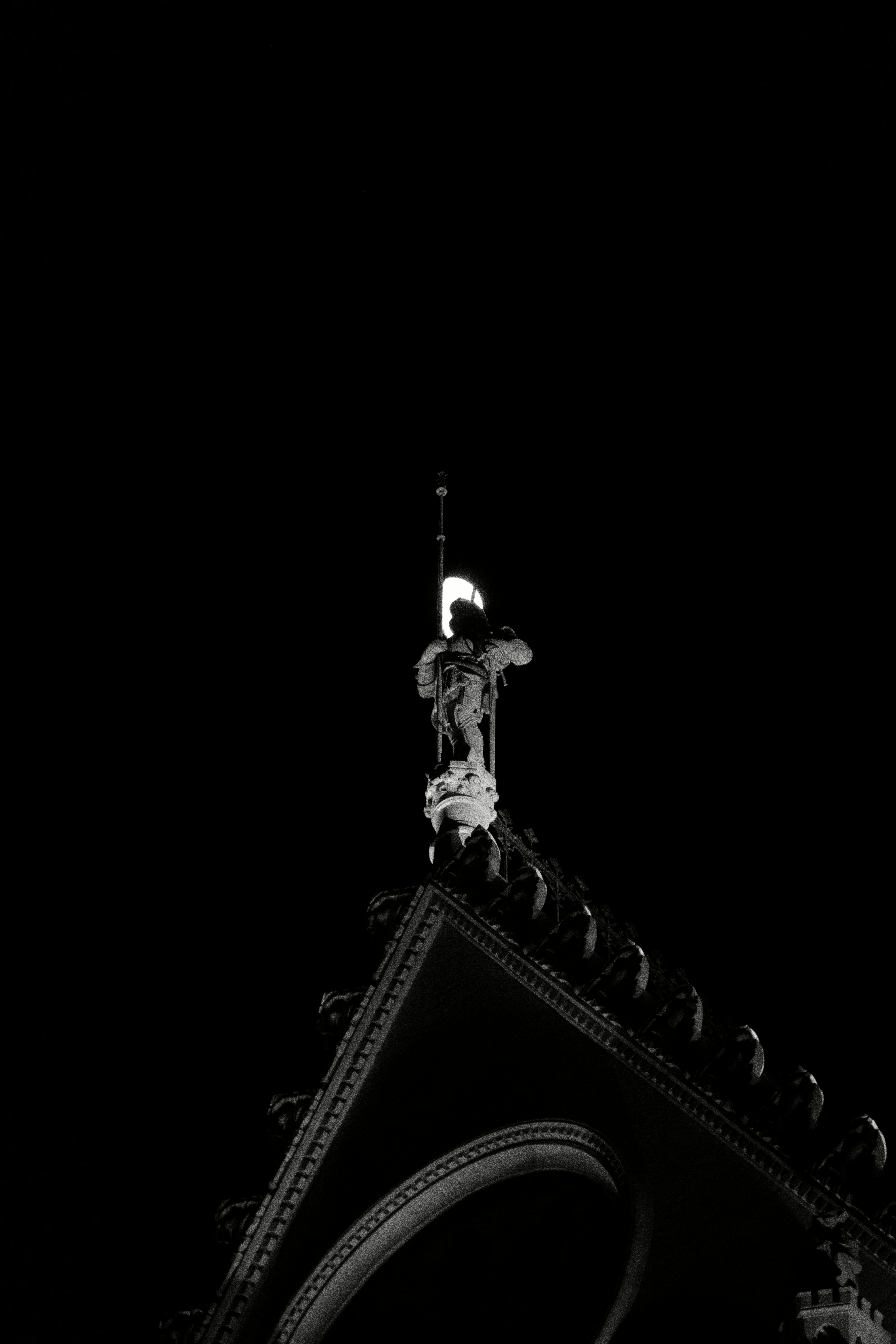 A Finial Silhouette: A Nighttime Peak on a Historic Roof
