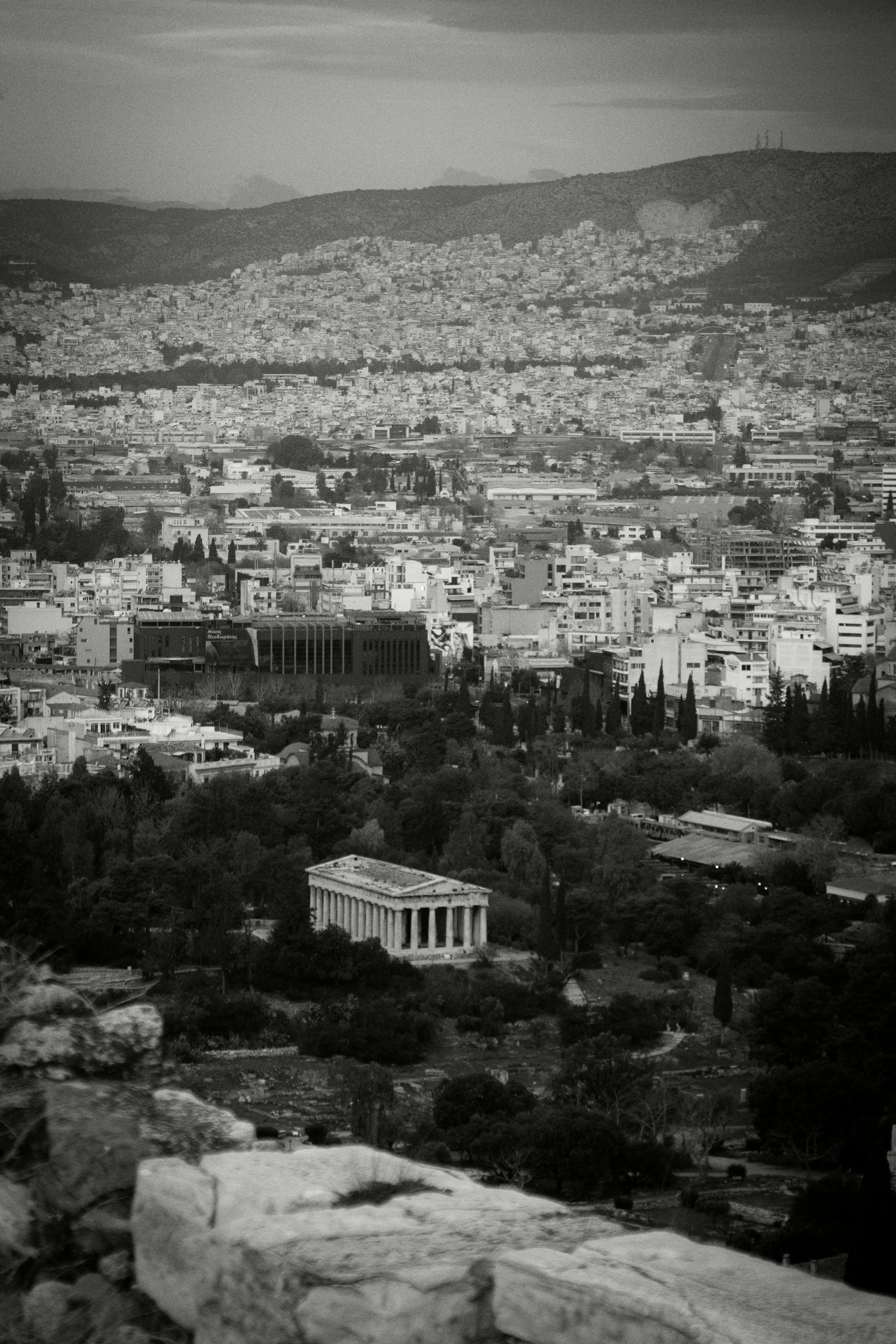 Ancient Temple Amid Modern Hills: A Monochrome Cityscape