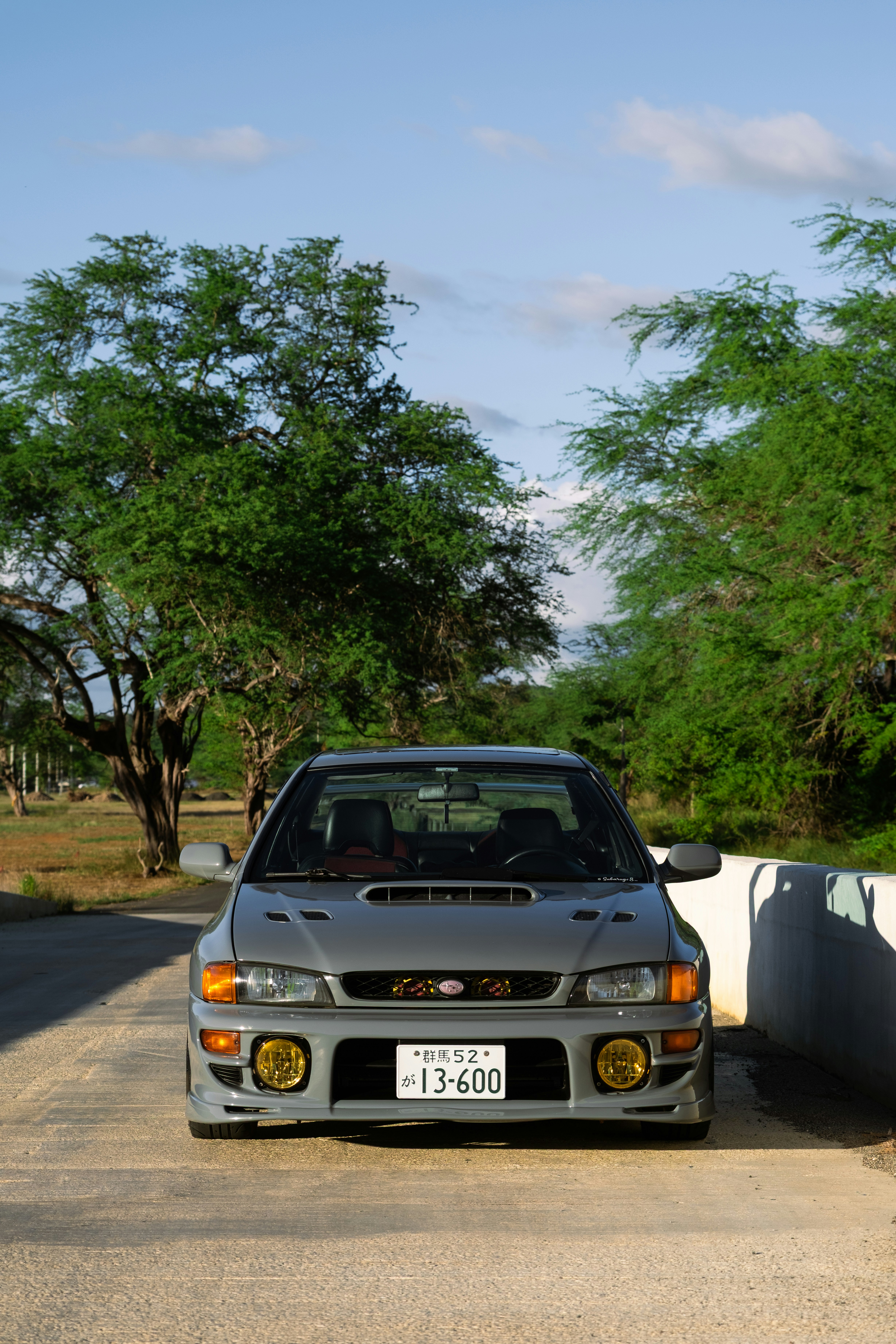 Front View of a Silver Subaru in a Tree-Shaded Parking Lot