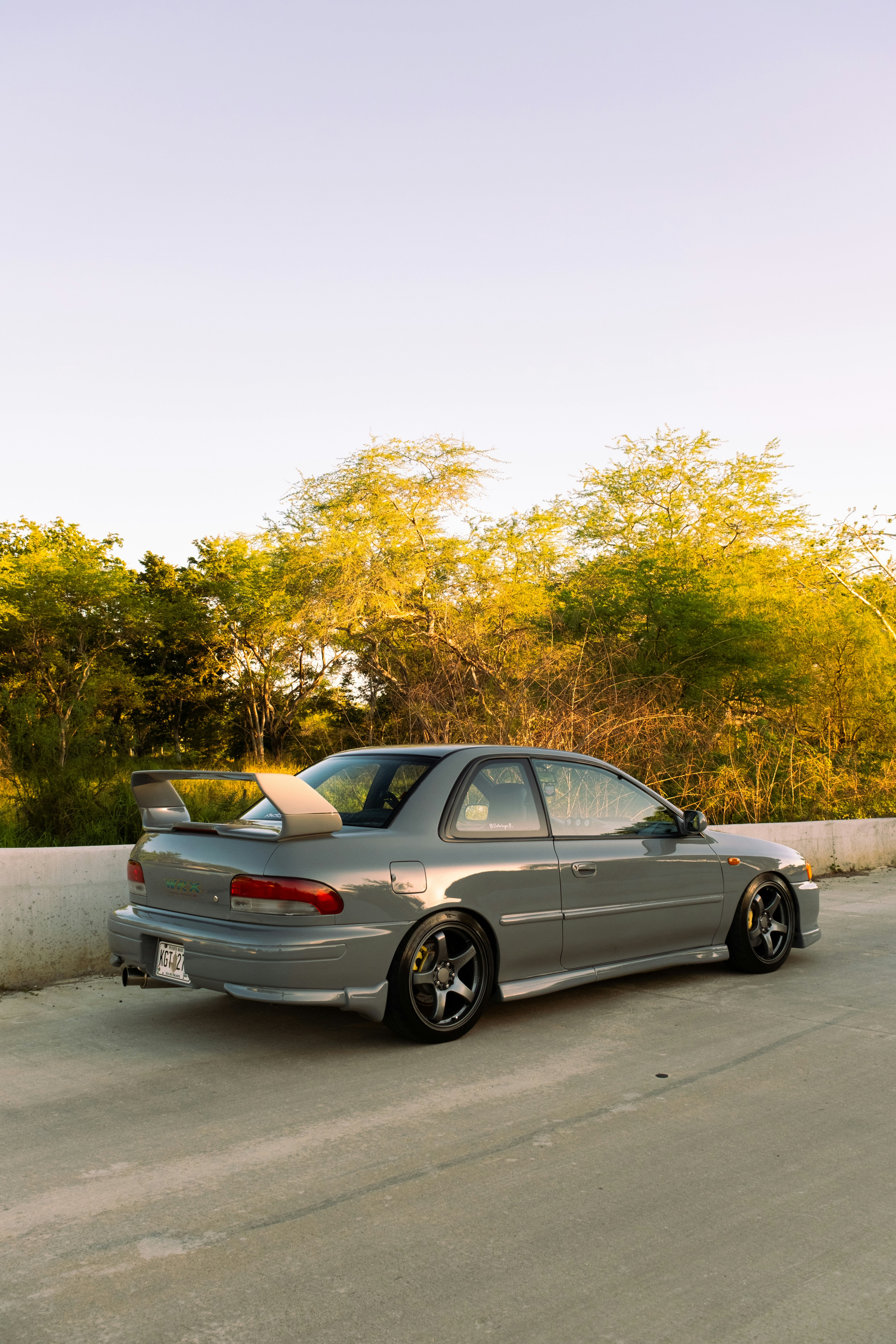Sleek sedan in late-afternoon light along a highway overlook