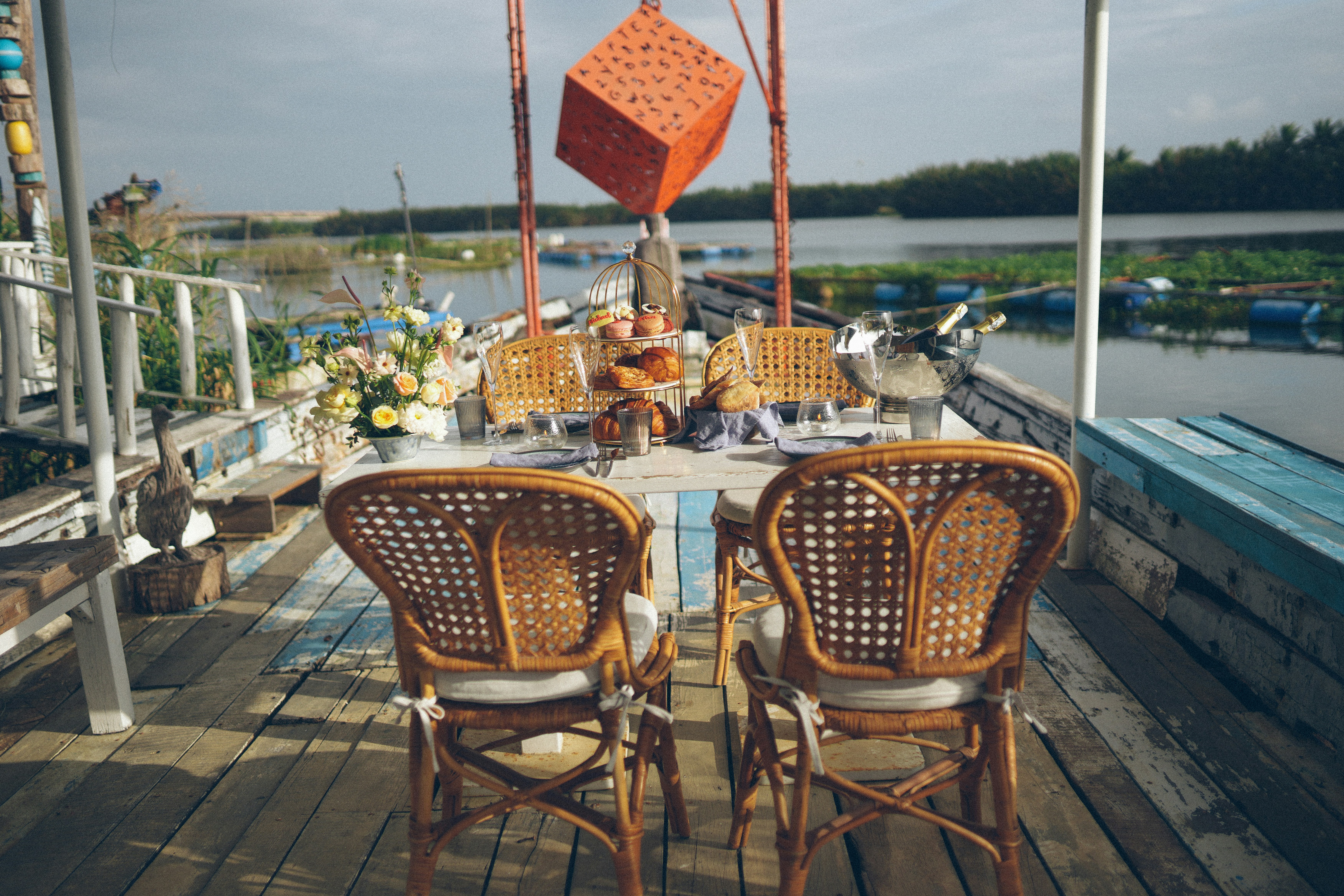 Dining on the Dock: a sunlit lakeside feast with woven chairs and a geometric centerpiece