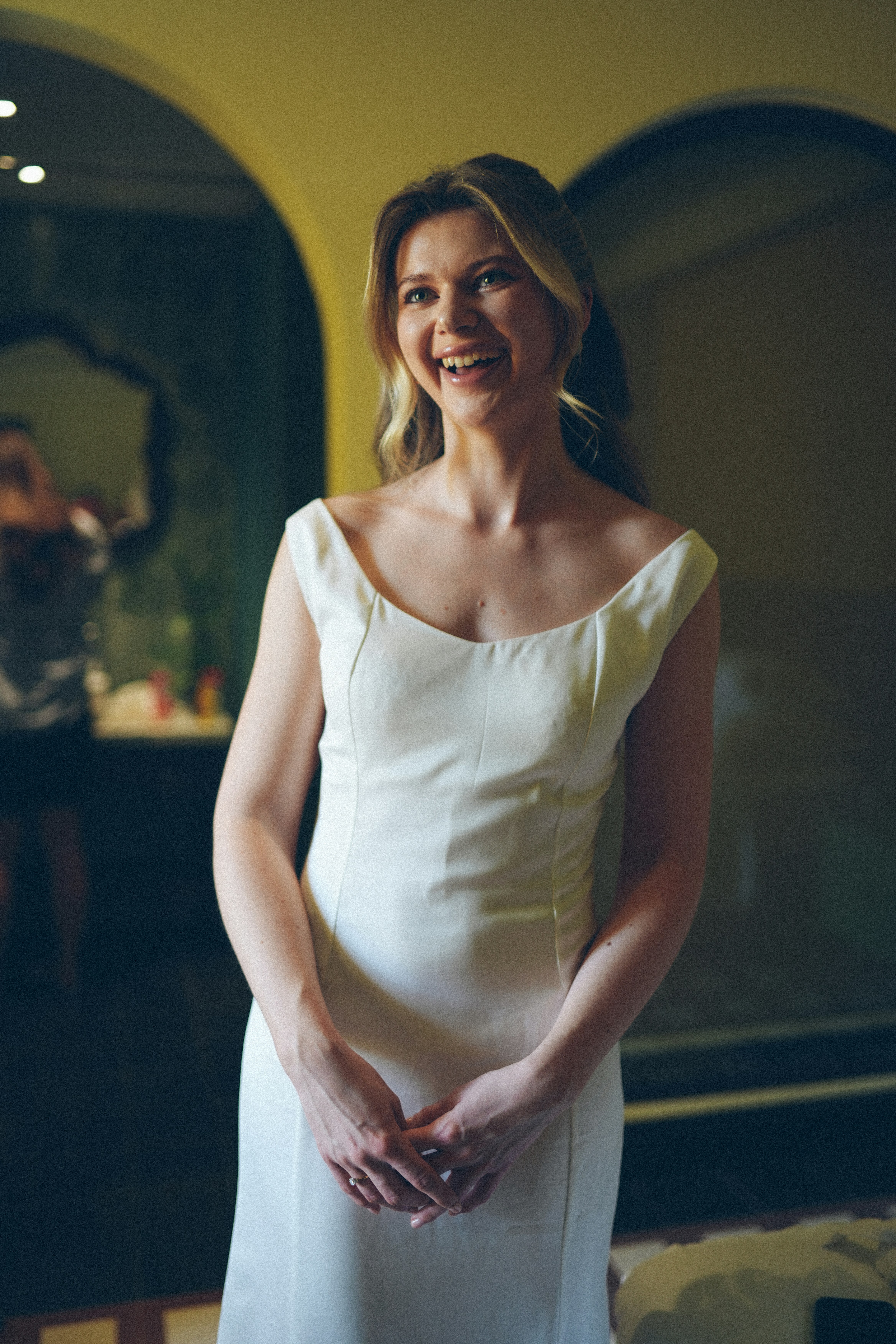 White-gown smile: a candid moment in warm indoor light