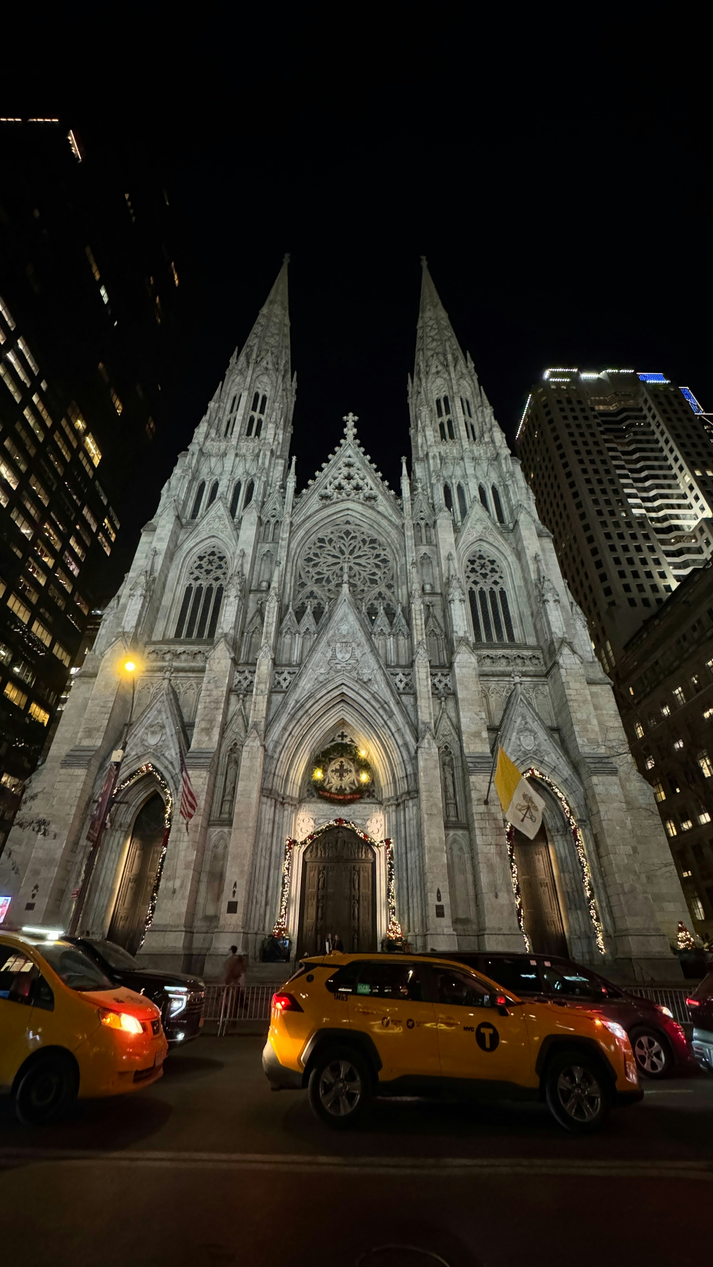 Midnight Gothic: St. Patrick’s Cathedral Surrounded by Neon and Taxi Lights