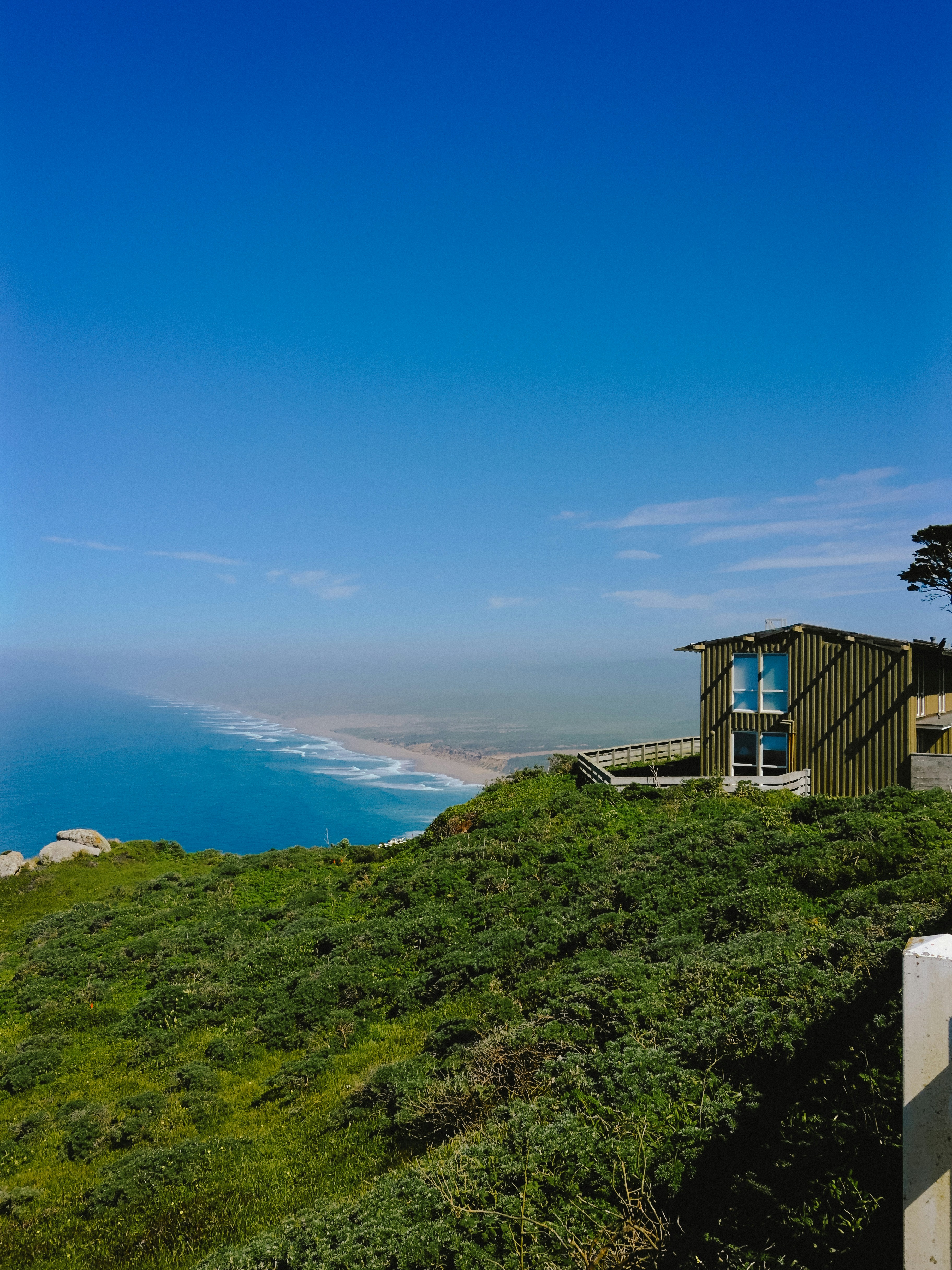 Modern house on a green hill overlooking the ocean
