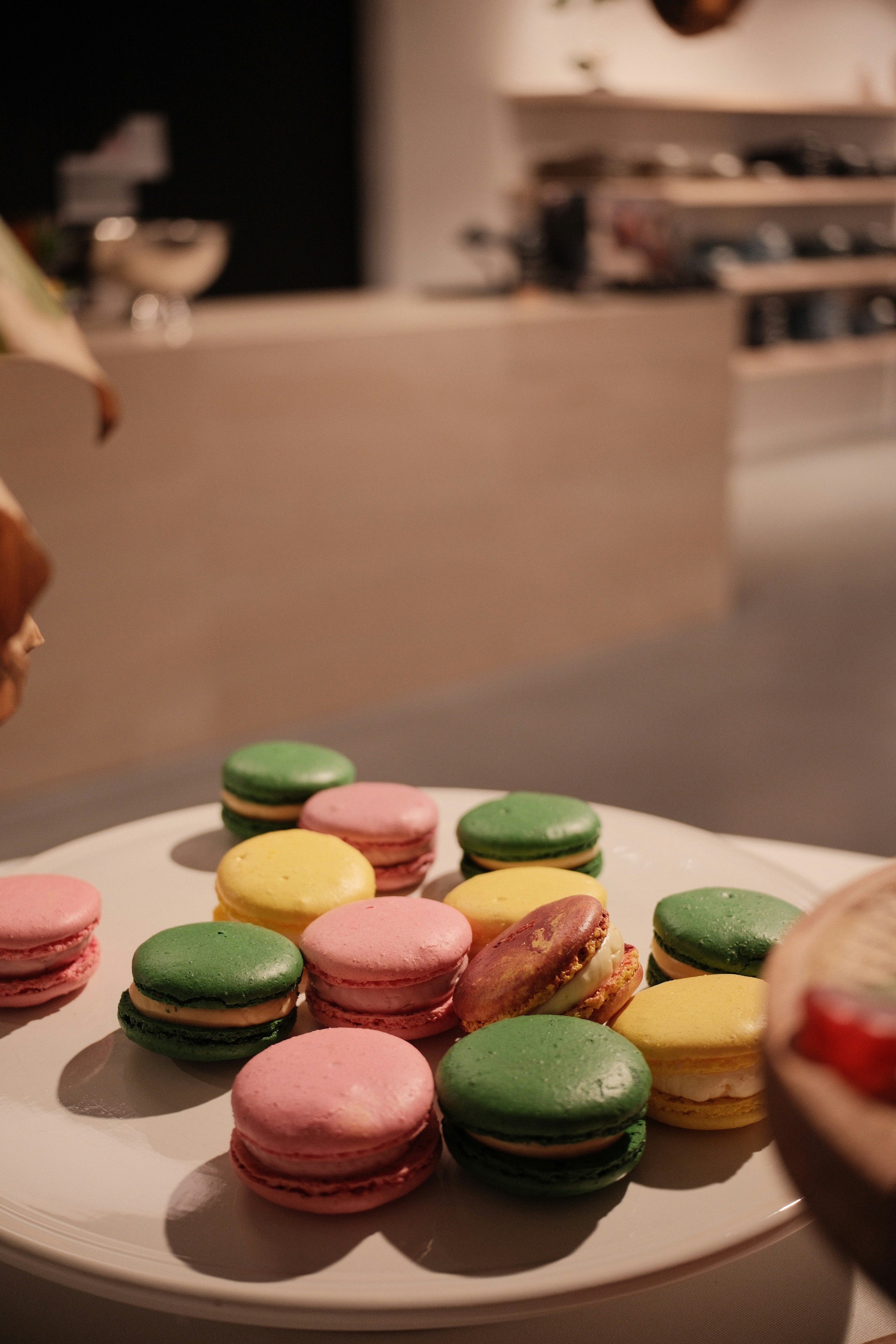 Plate of pastel macarons at a softly lit dessert table