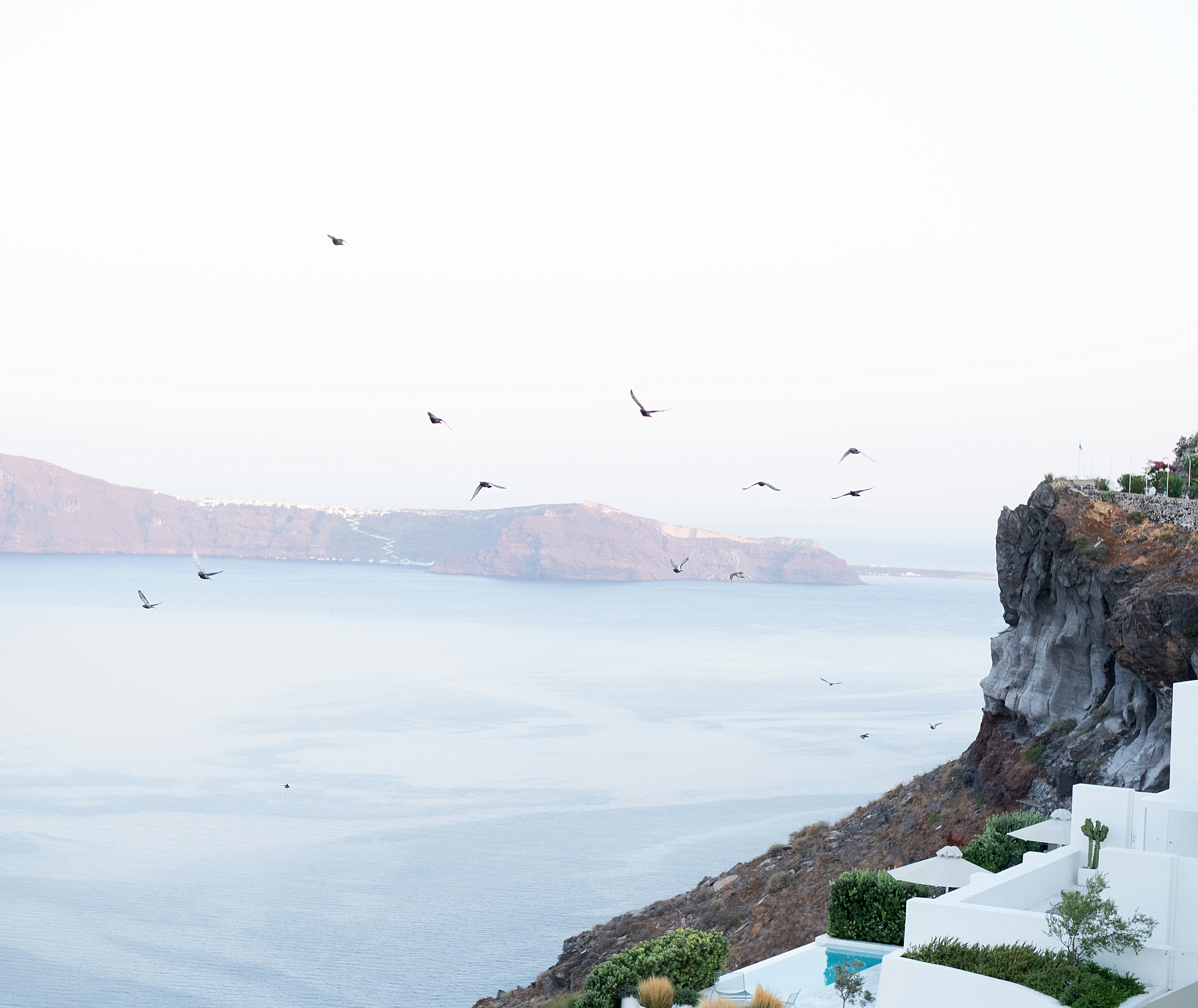 Cliffside White-washed Villas Look Out Over A Calming Sea