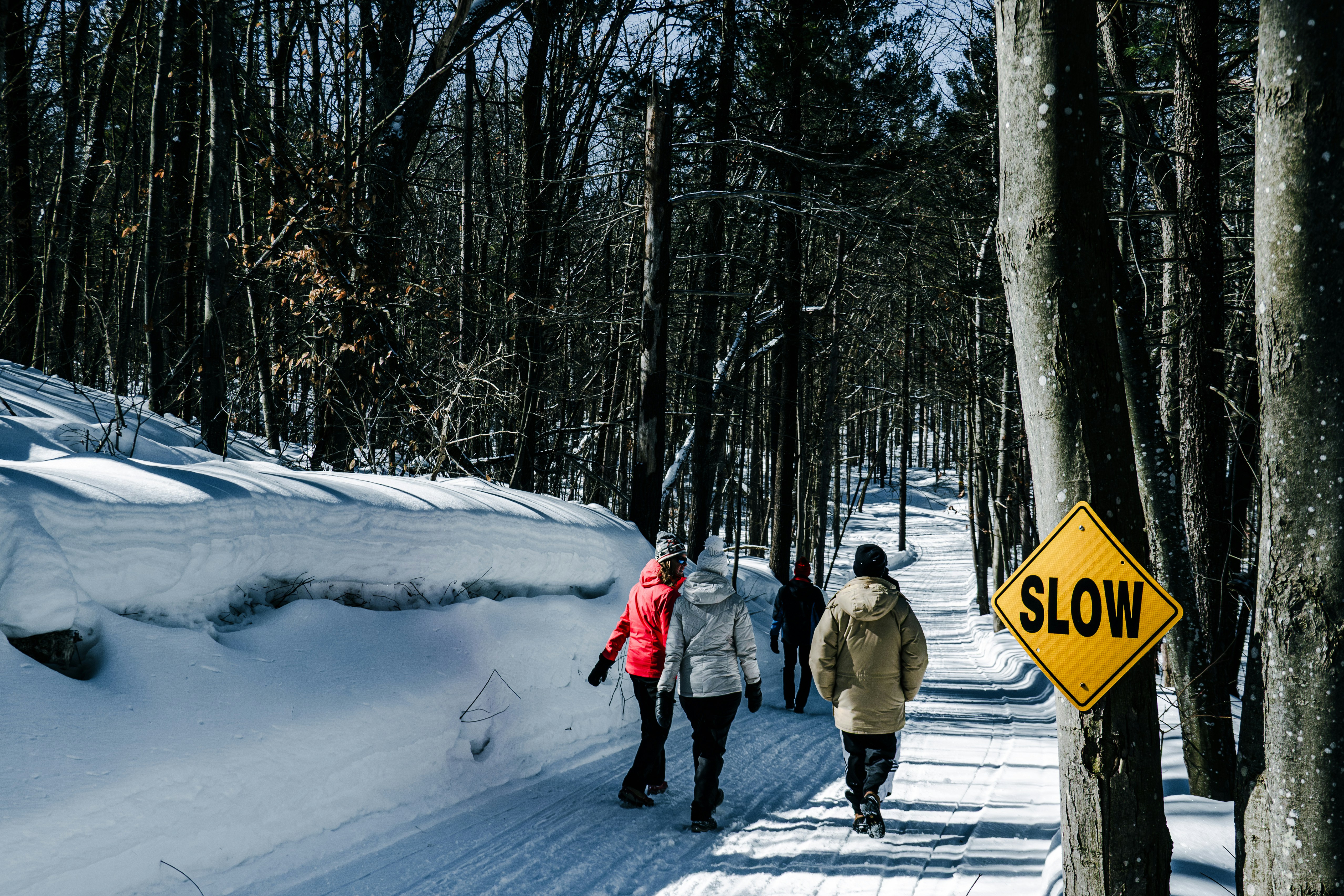 Snowy Trail Stroll Beneath a Slow Sign