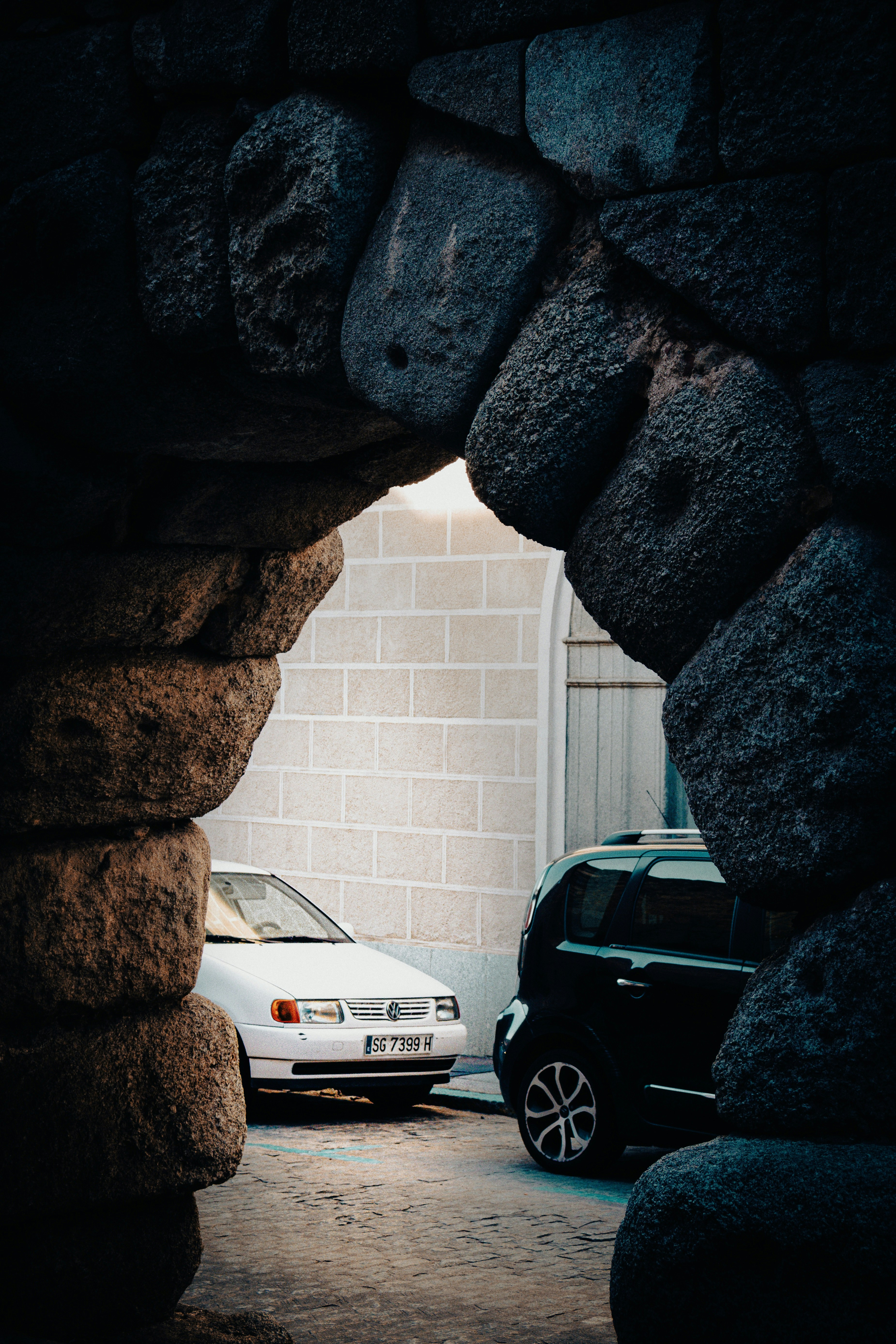 Stone Arch Framing a Quiet Car Courtyard