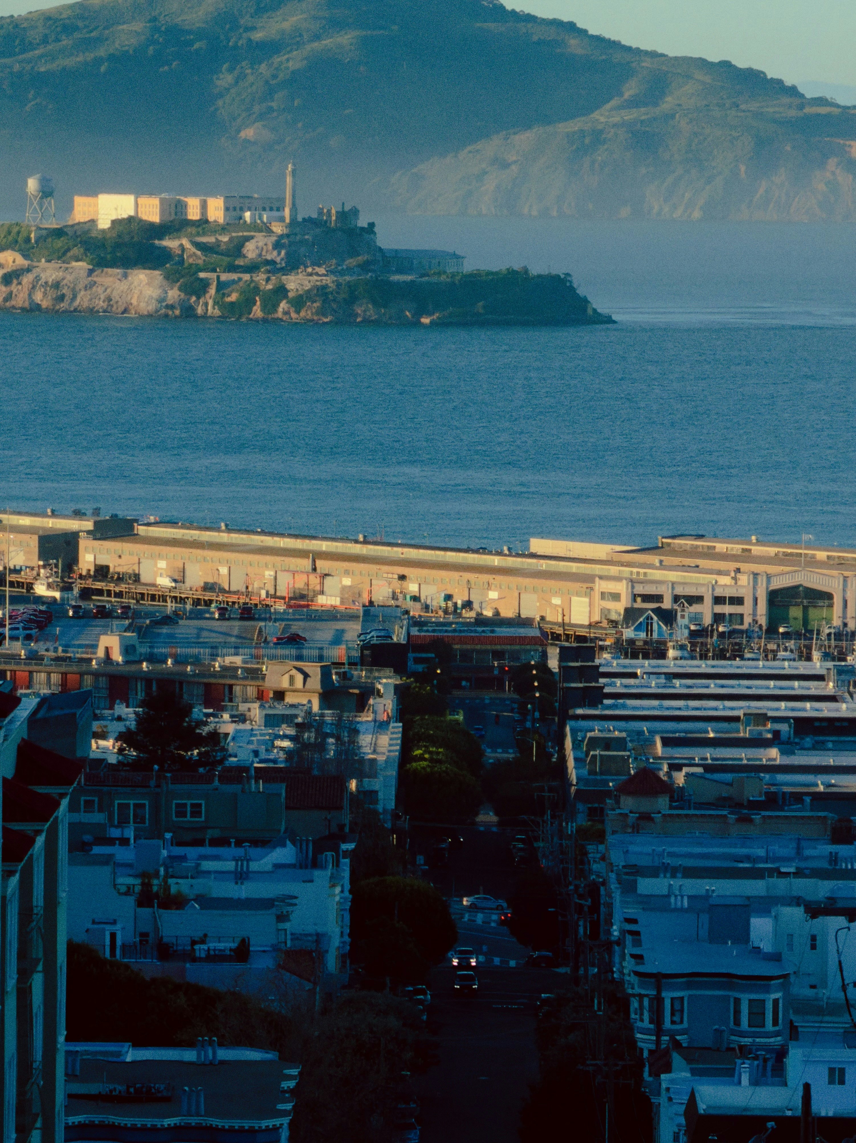 Coastal Cityscape with Island Fort Under Distant Hills