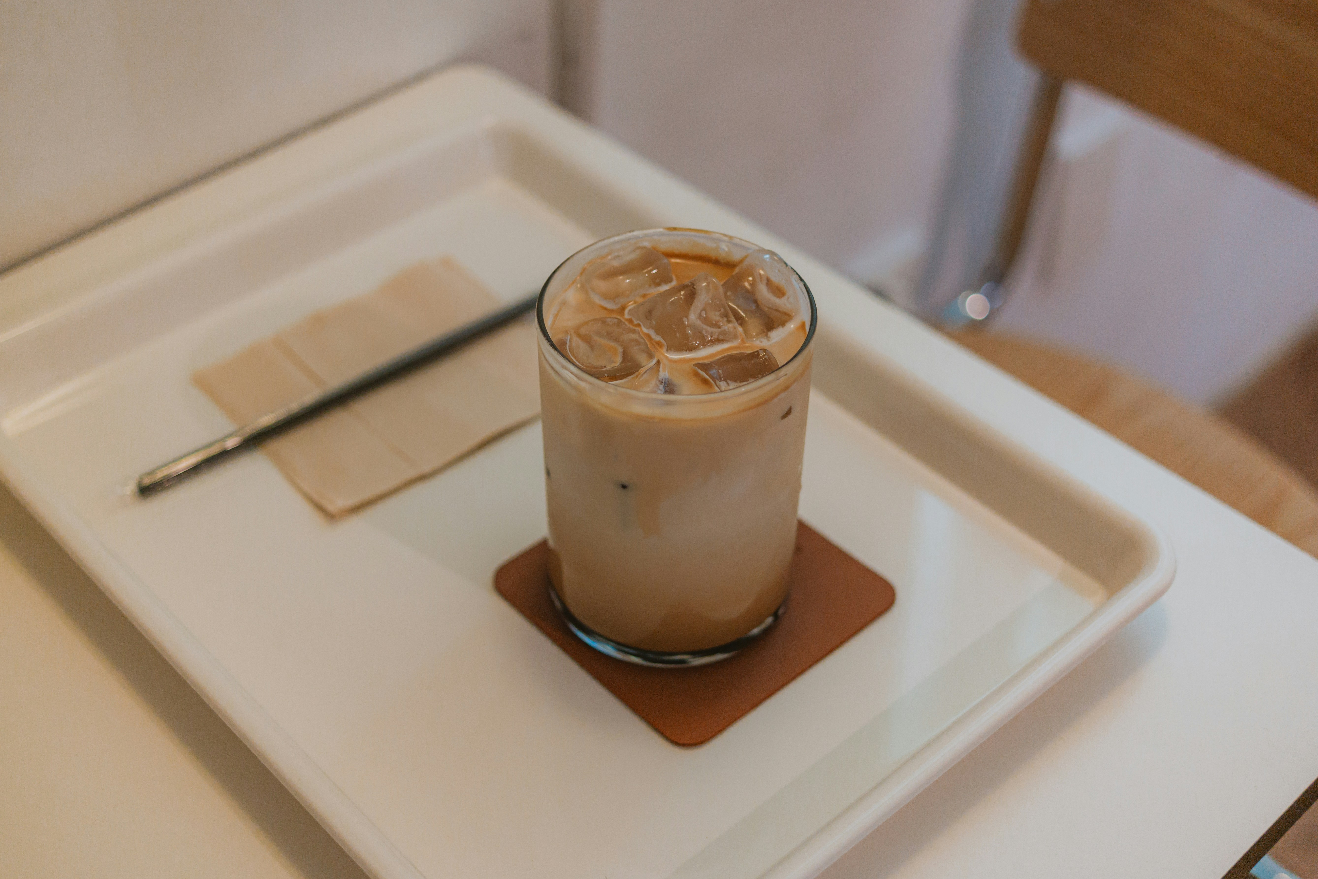 Iced coffee with cream and ice on tray