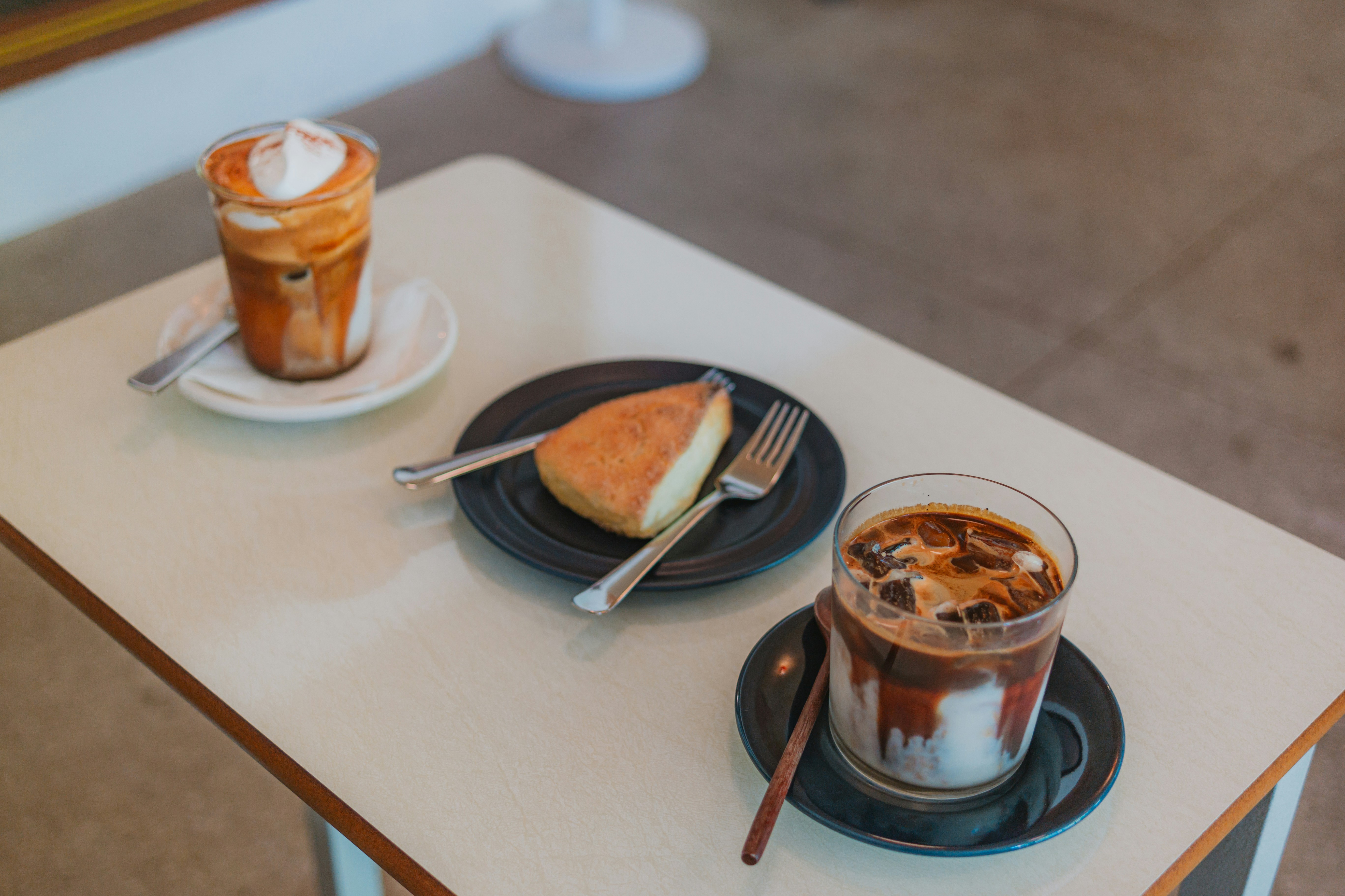 Two iced coffees and a pastry on a table