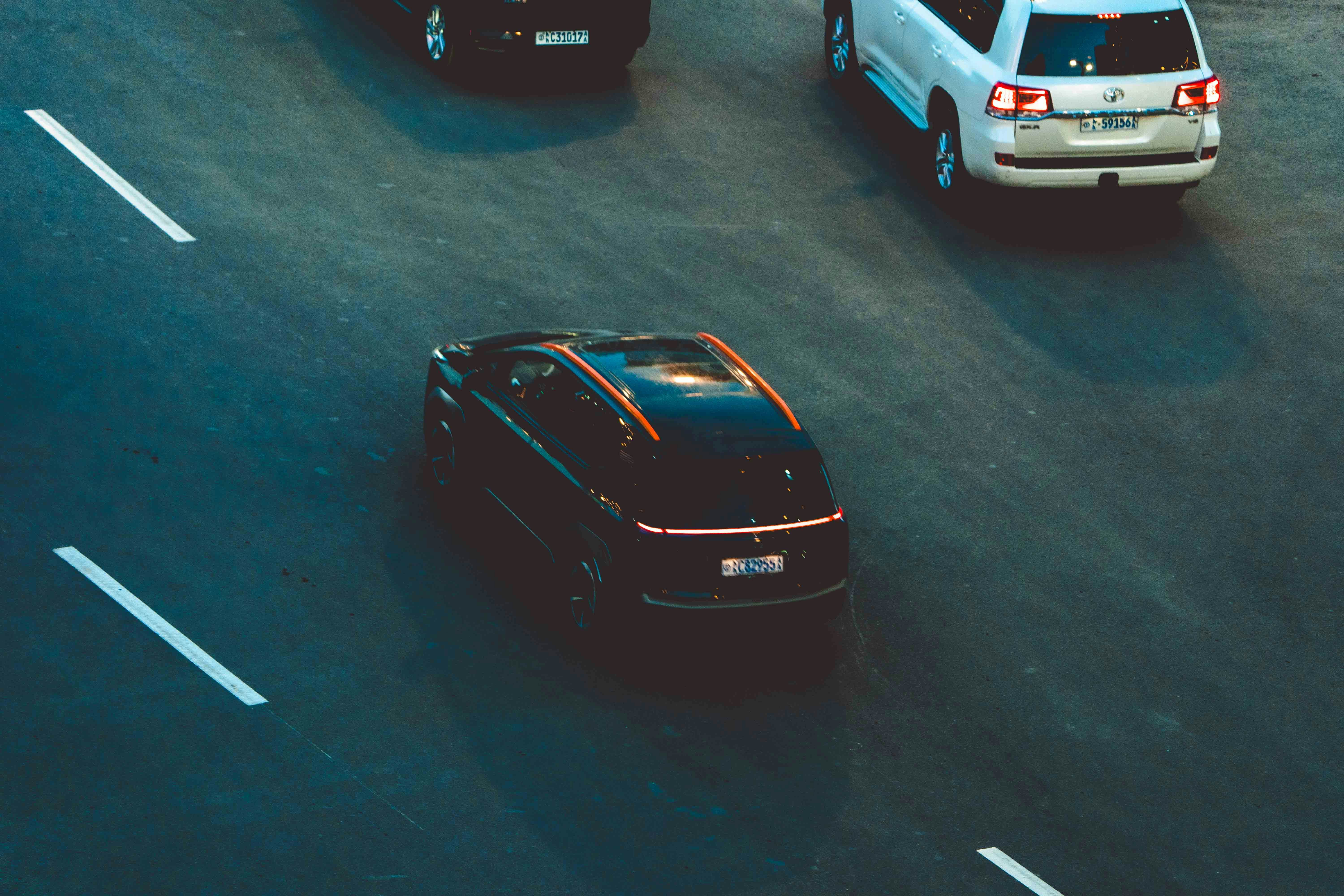 Cars driving on a dark highway at night.