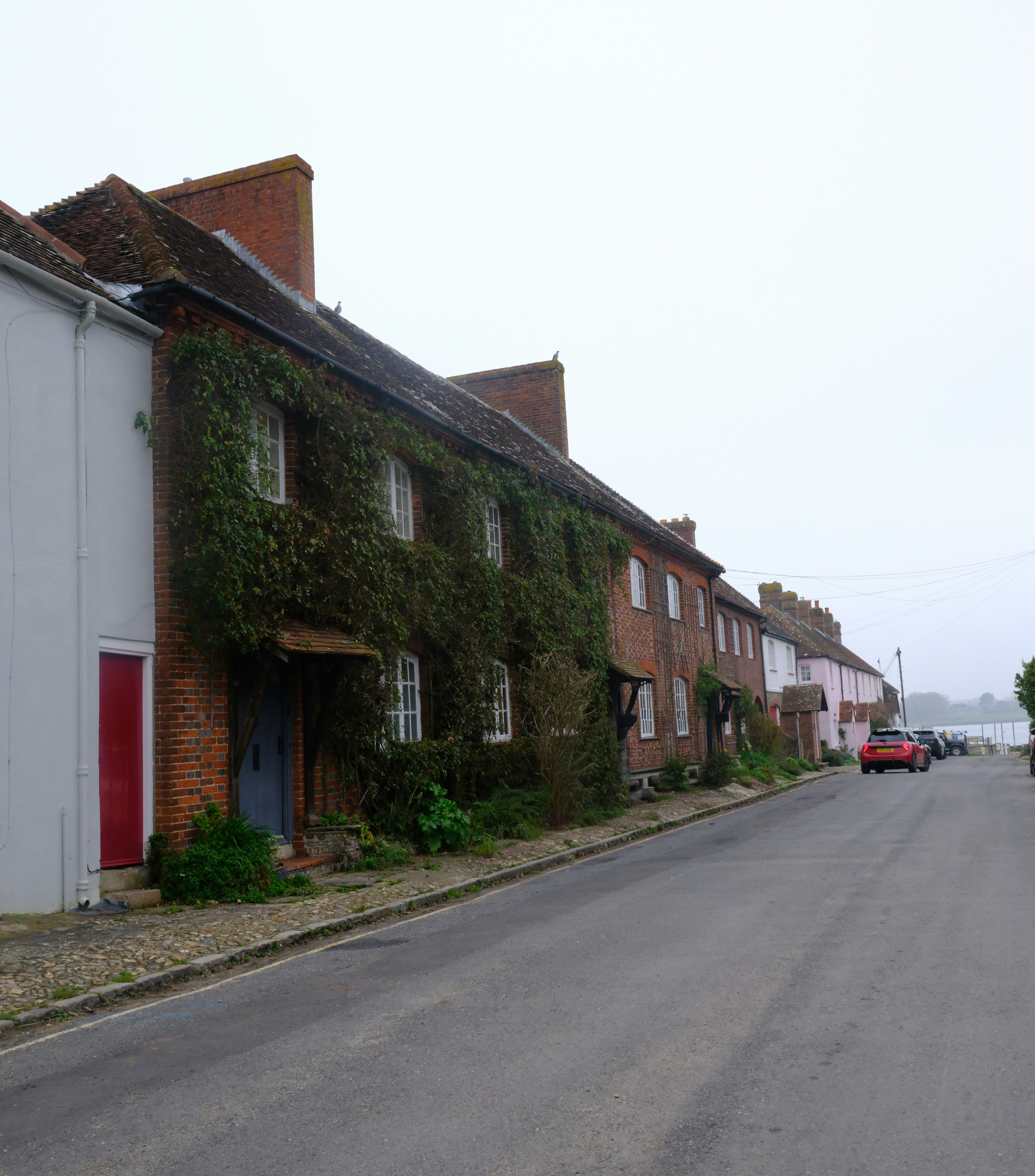 Ivy-clad row houses along a misty coastal street