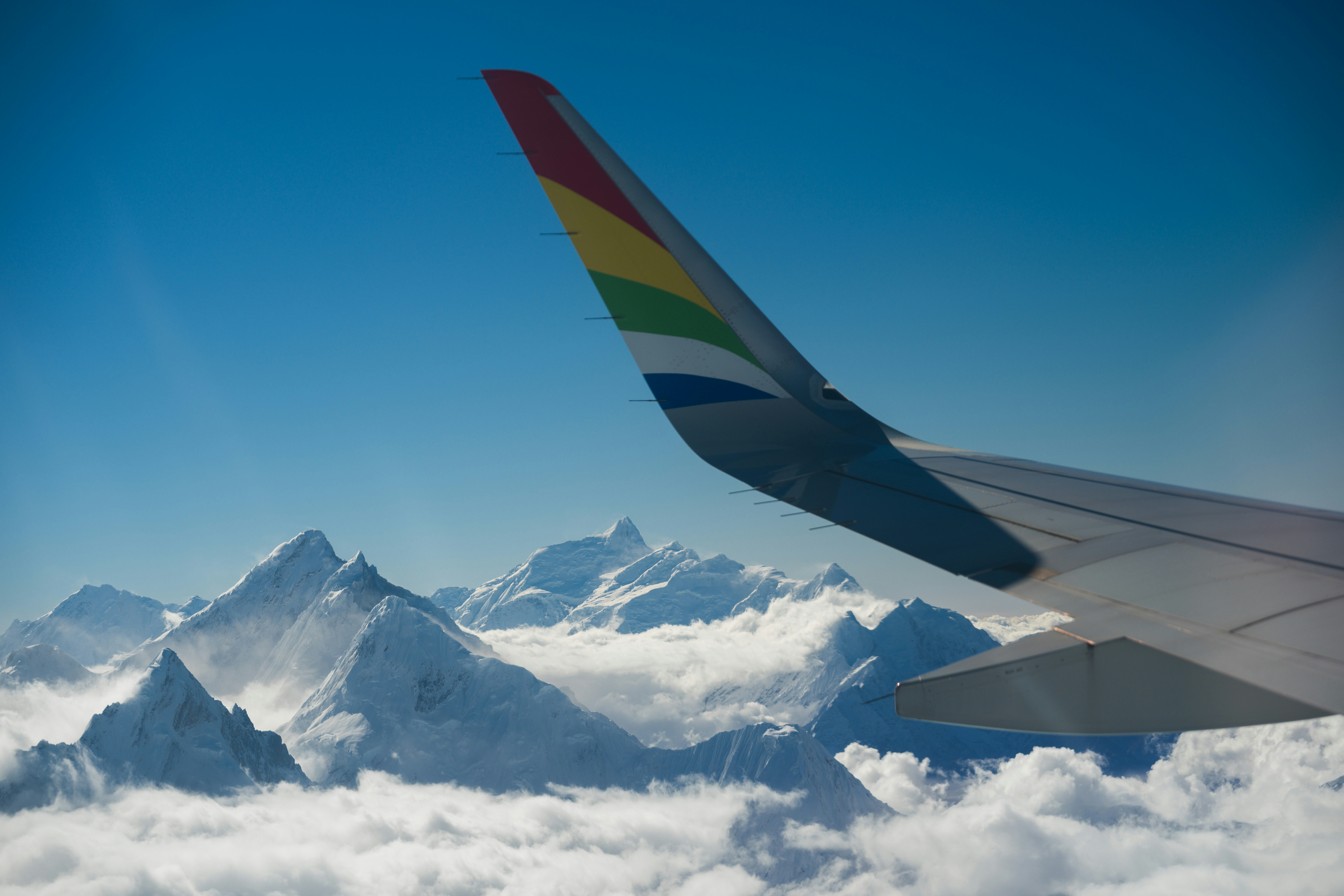 Rainbow-tail Wing Above Alpine Clouds