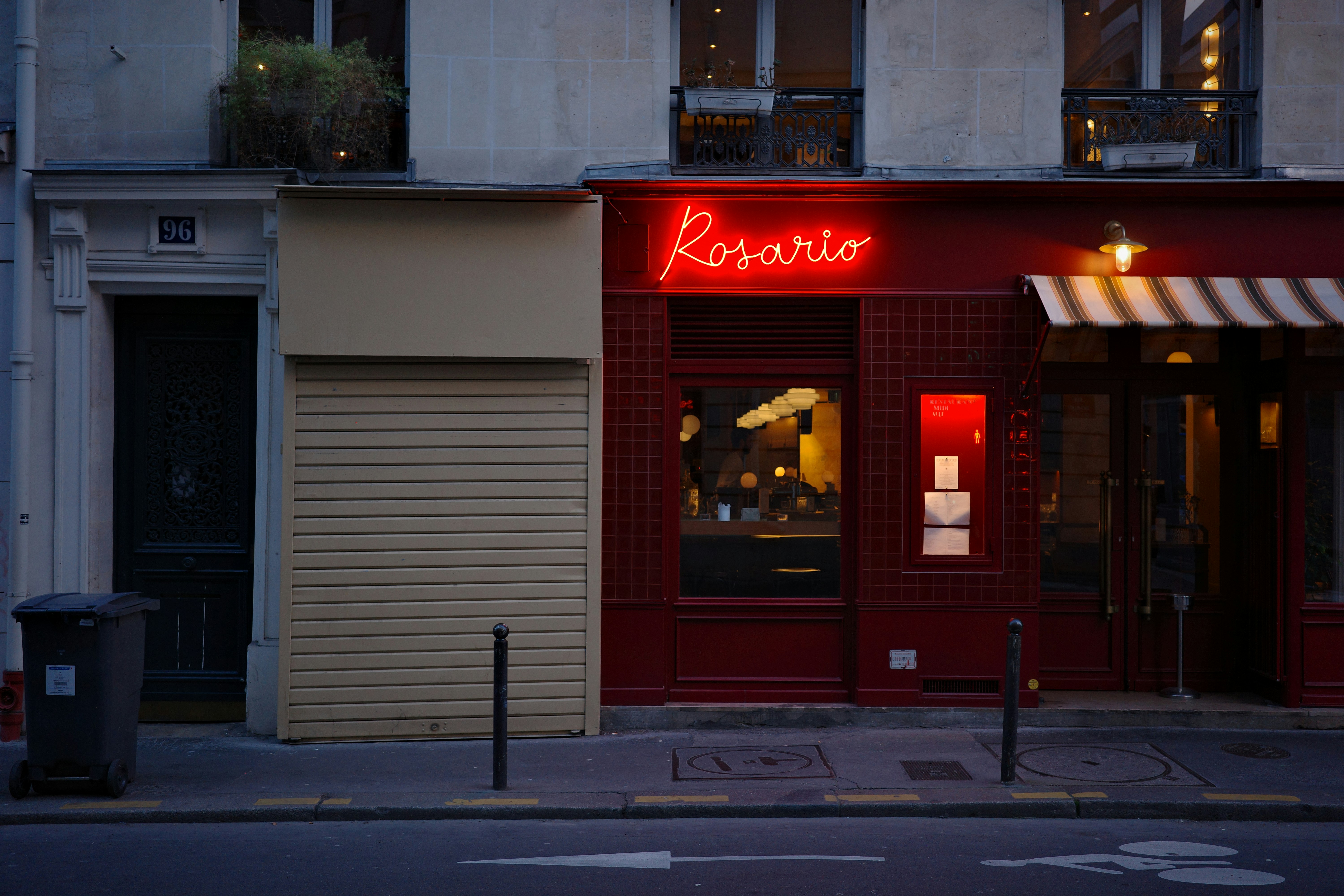 Neon Sign Over a Quiet Red-Fronted Corner Store