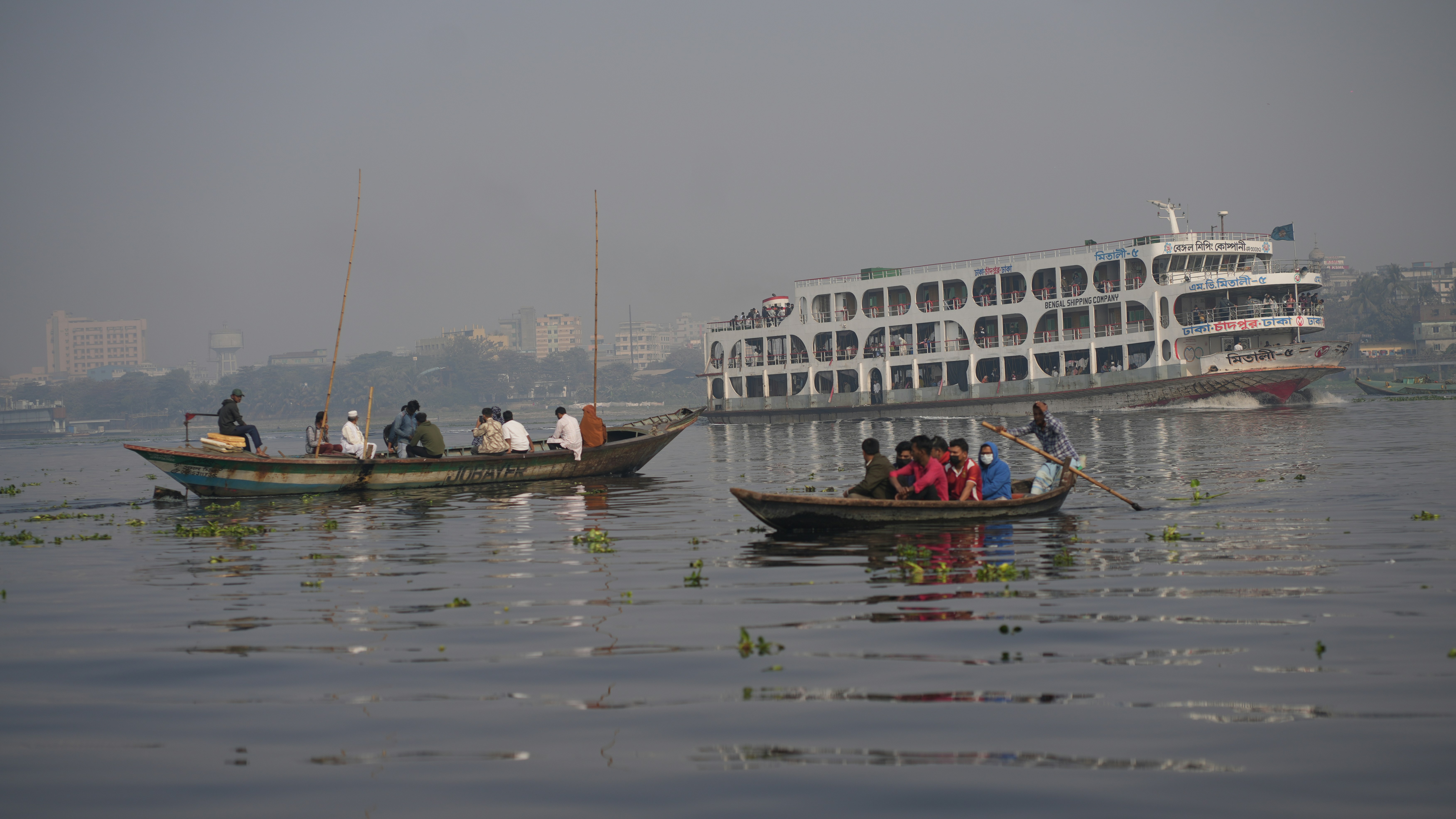 Riverine Caravan: Boats Skimming Mist on a Calm Waterway