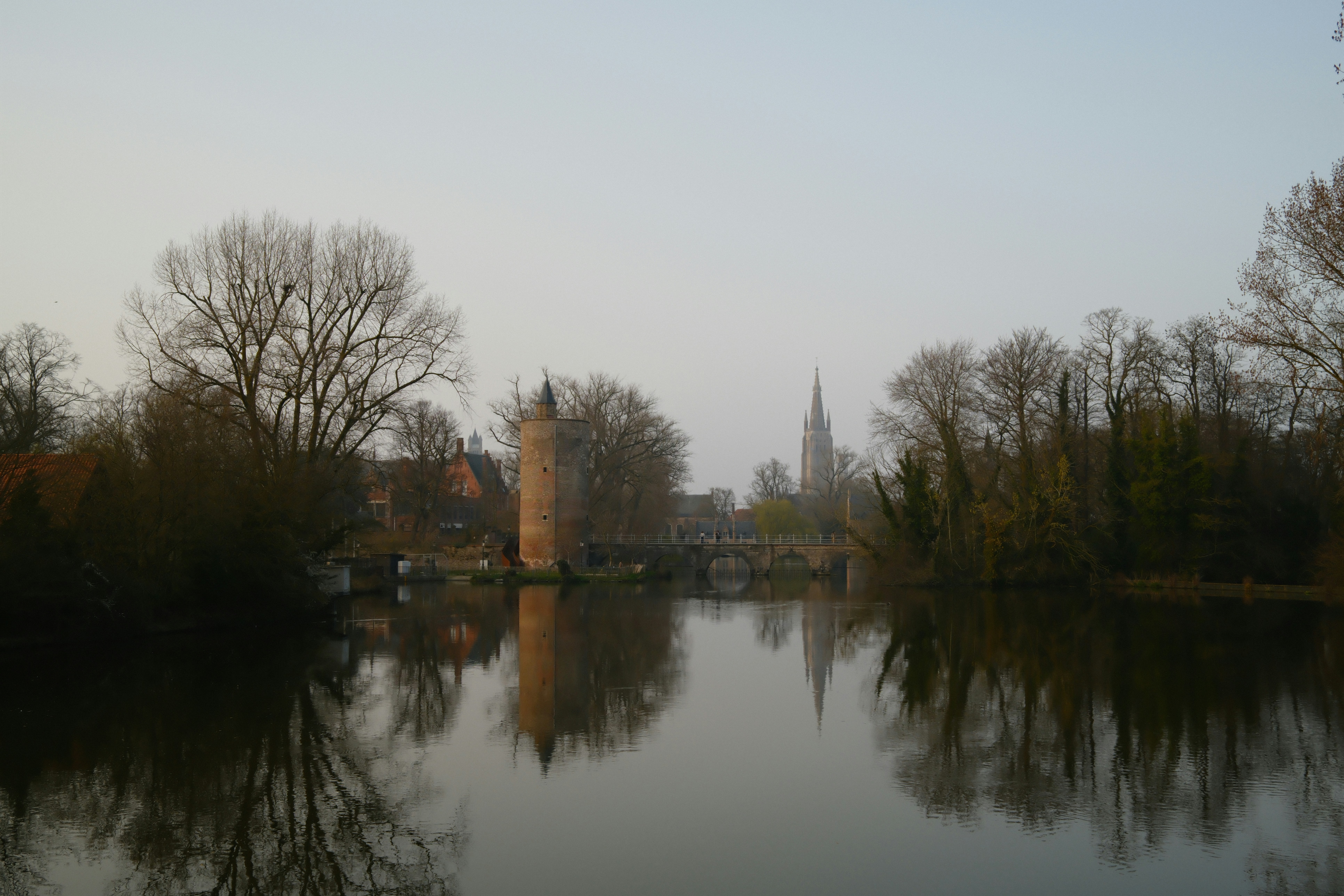 Reflections Over the River: Towers Echo Across Quiet Water