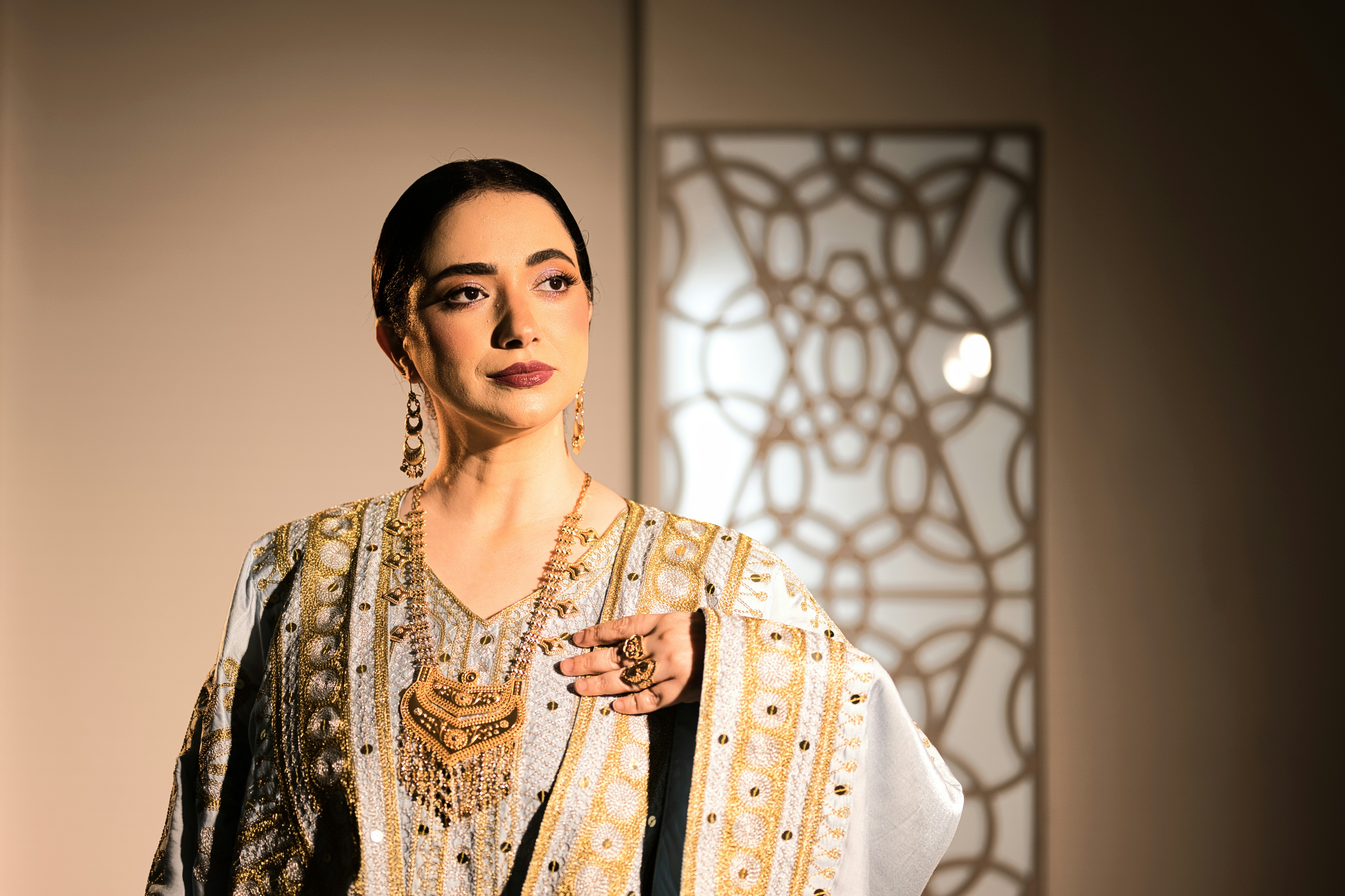 Regal Gaze: Adorned in Heritage Fabric Under Warm Studio Light