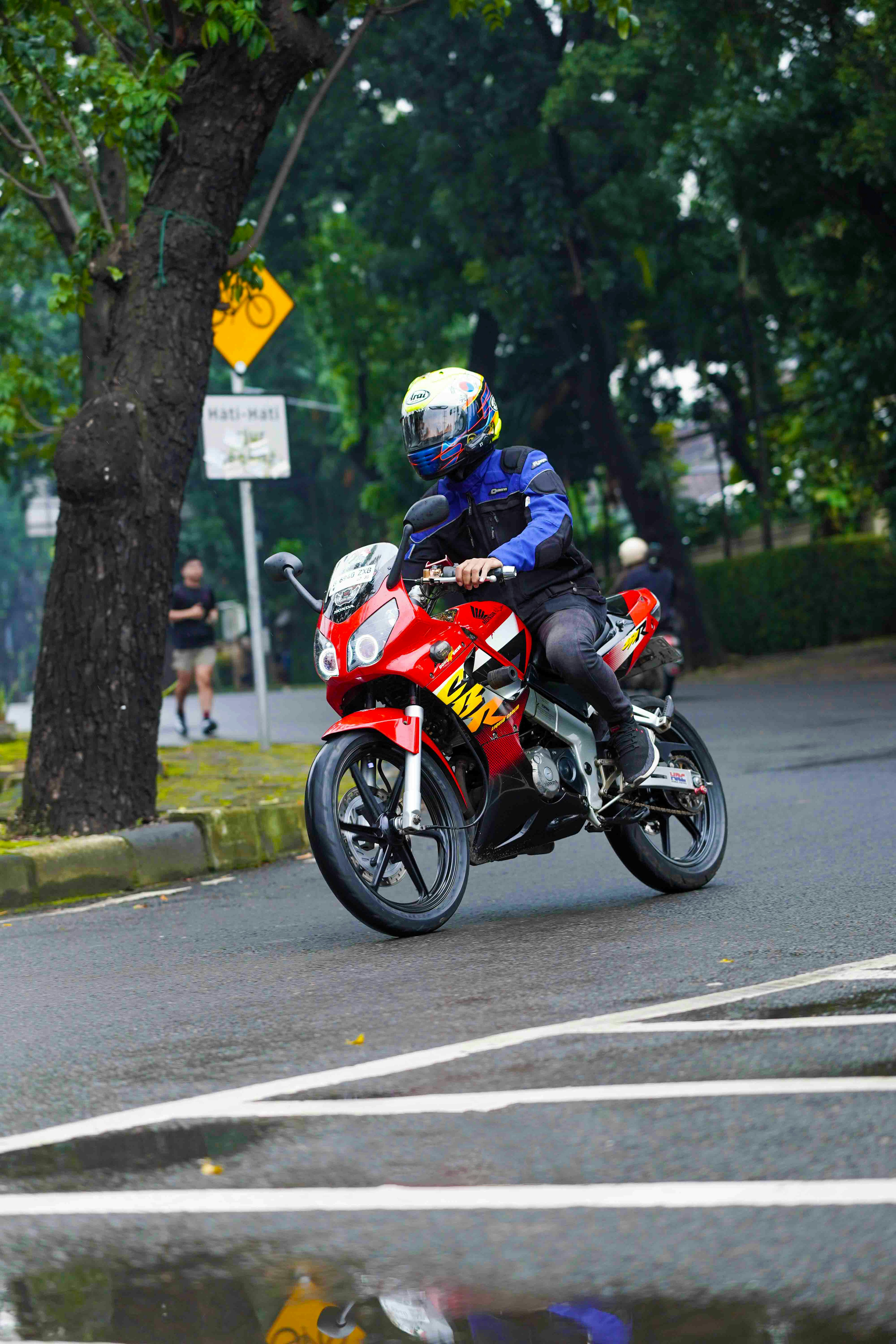 Rider in Blue: On a Red Sport Bike Through a Quiet City Street