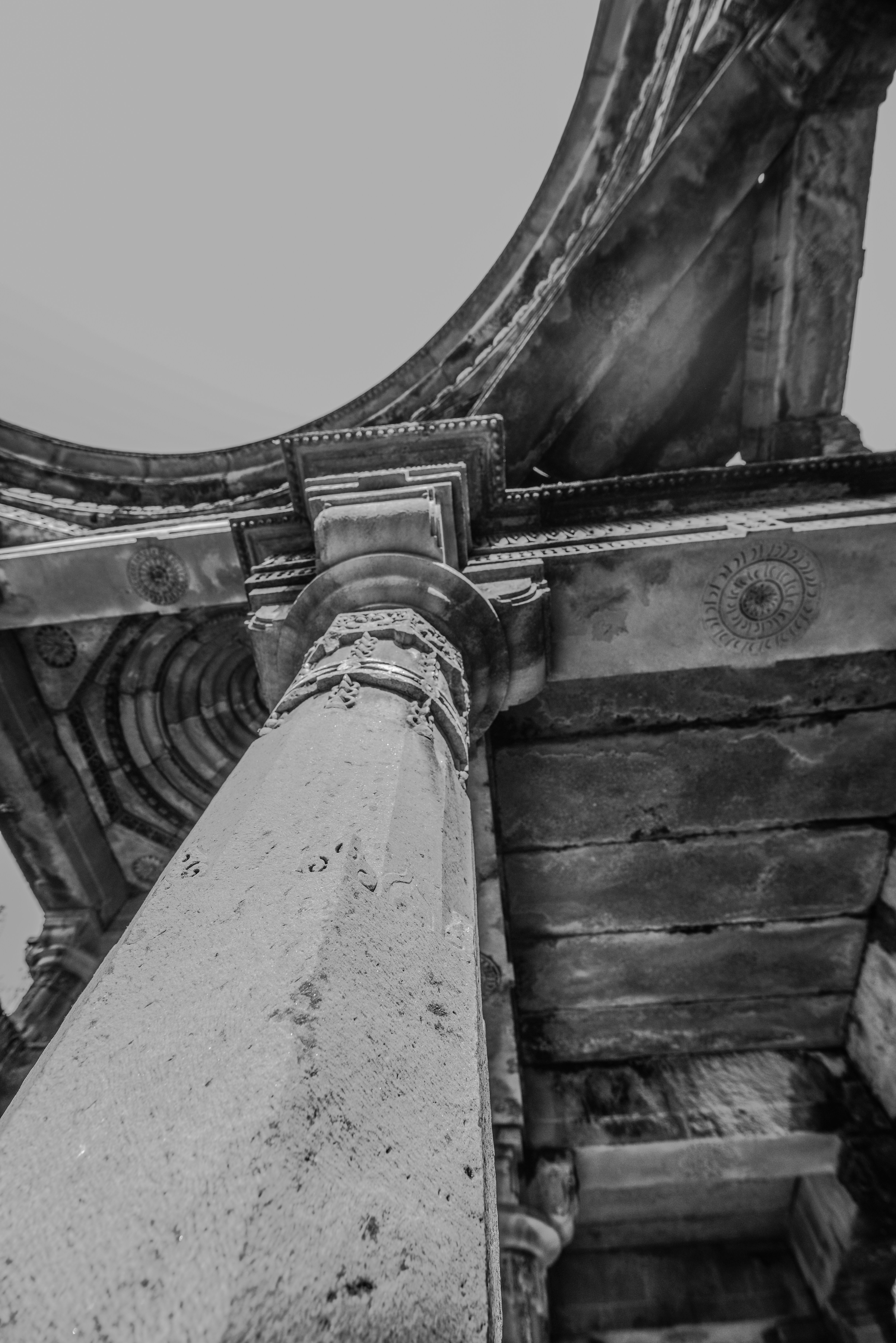 Upward Gaze: A Weathered Column Reaches Toward the Arch