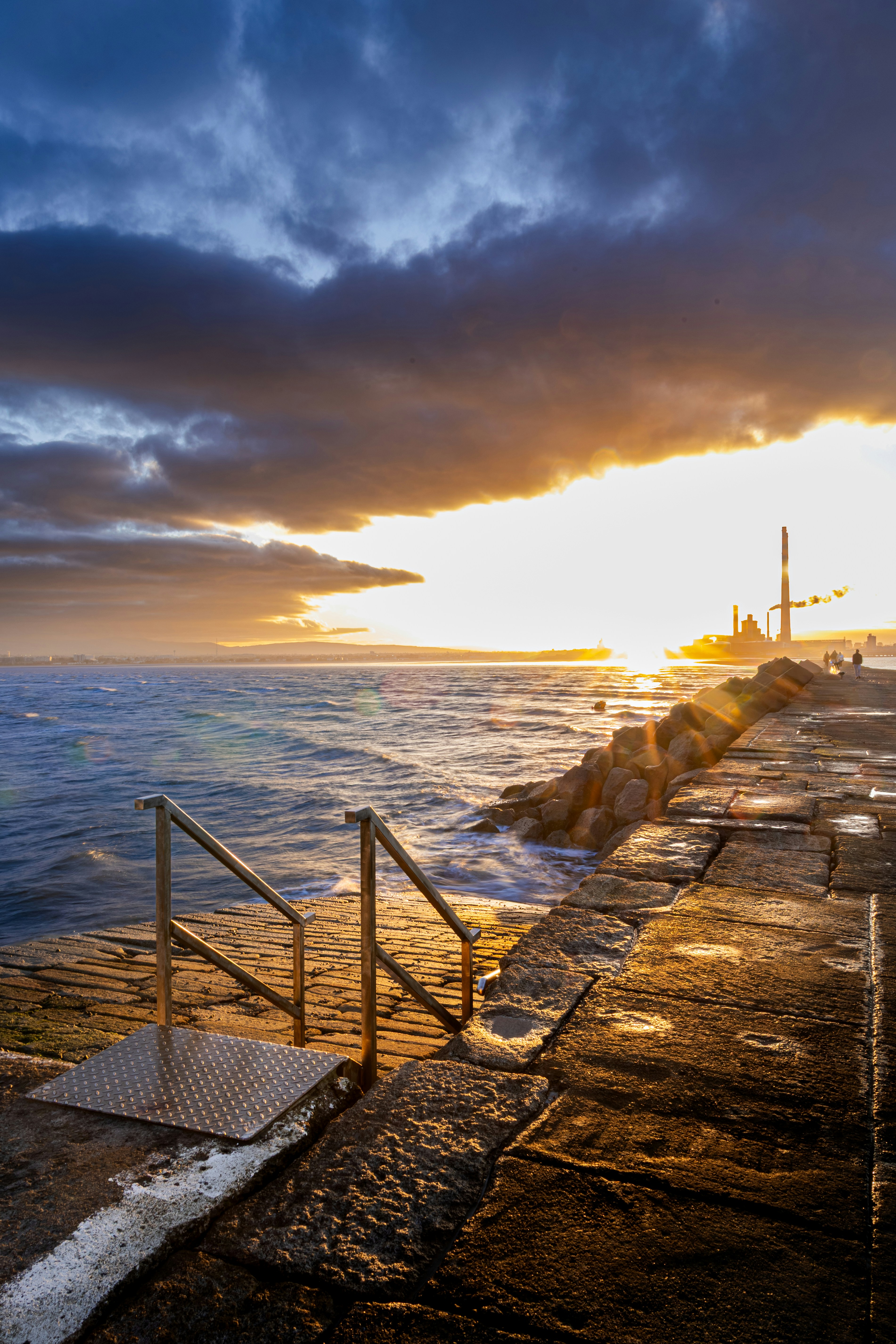 Sunrise Over a Weathered Pier: Light, Water, and Stone