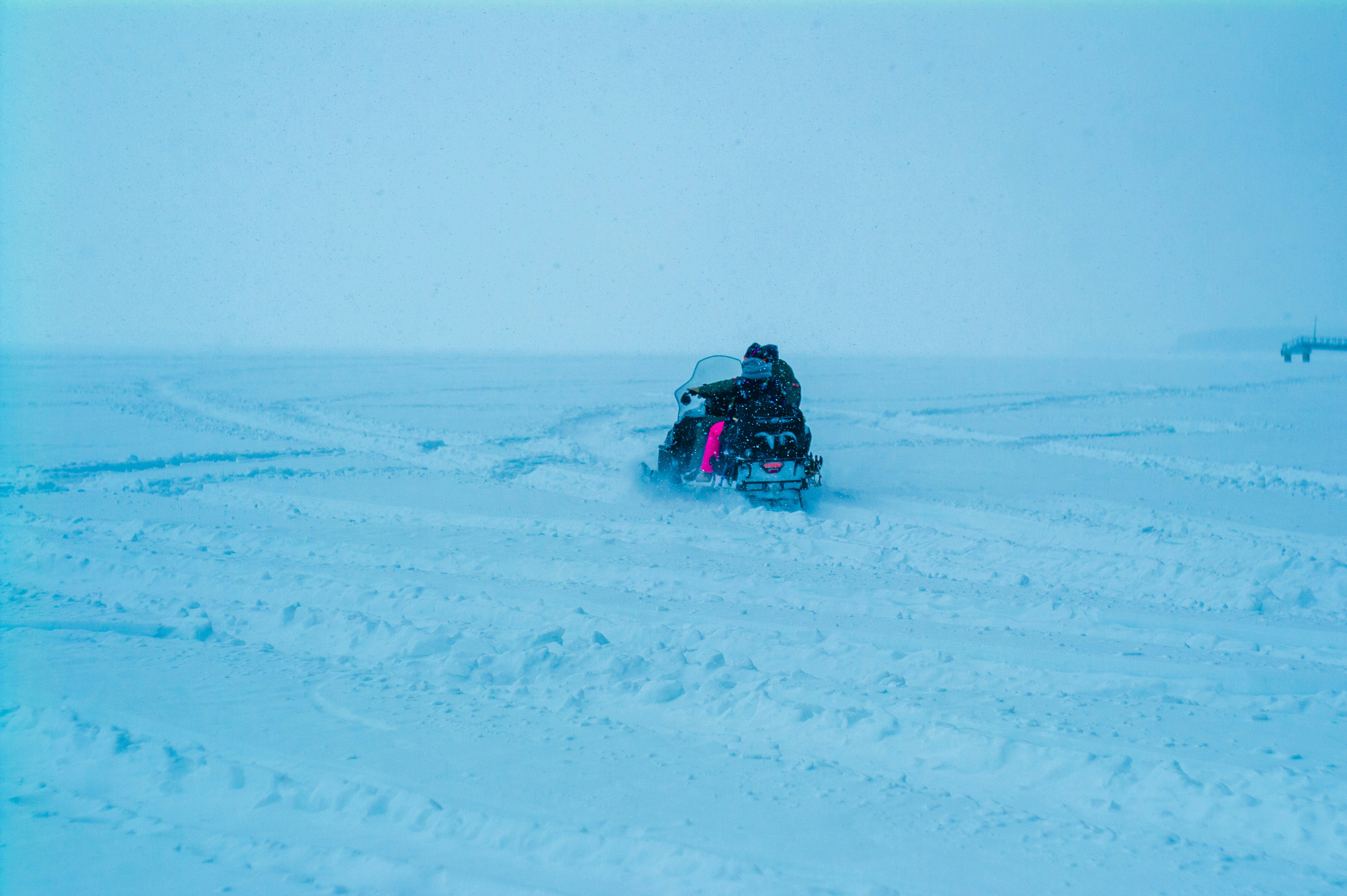 Snowmobile driving across a snowy landscape