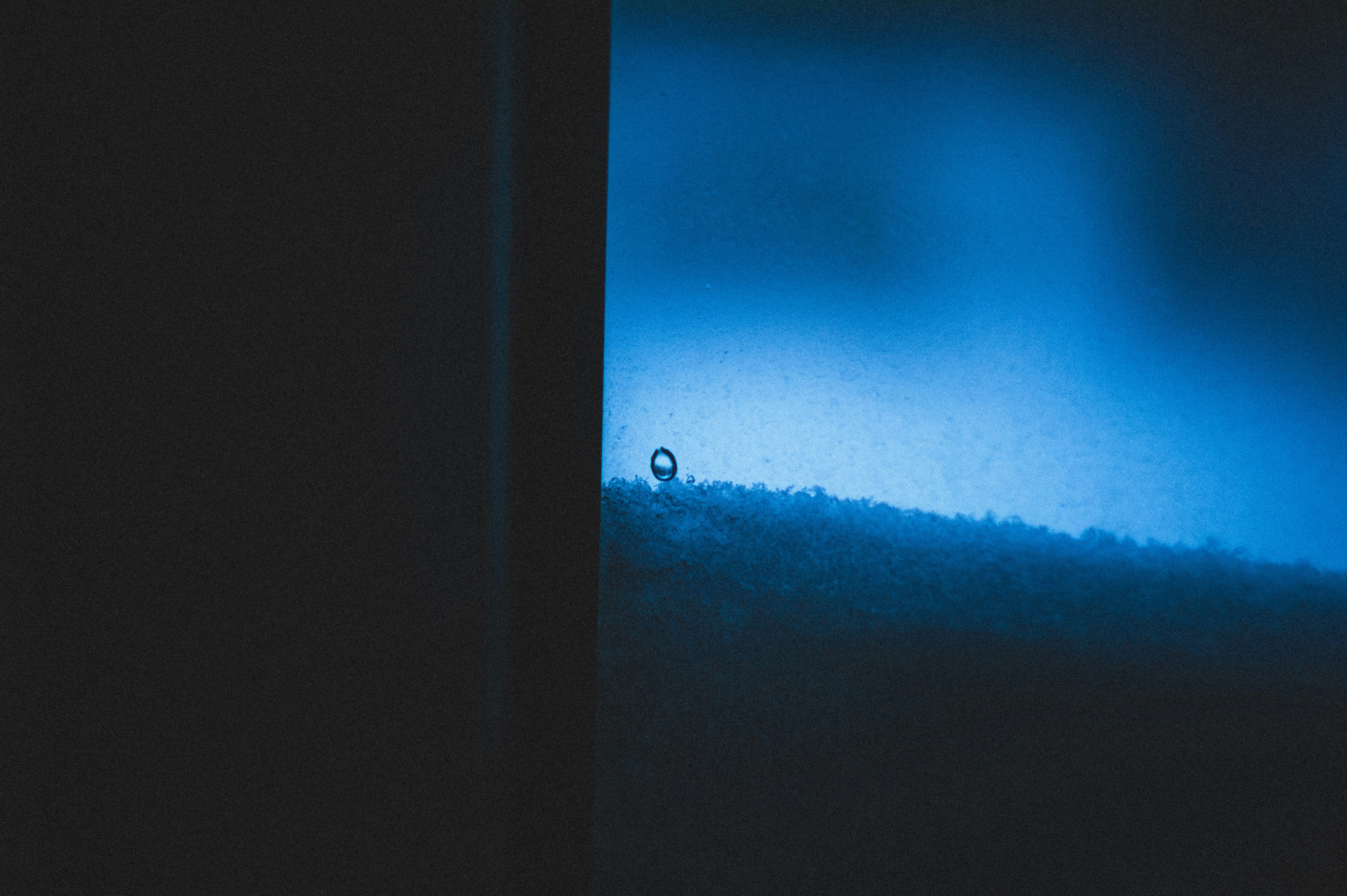 A single water droplet on a snowy surface