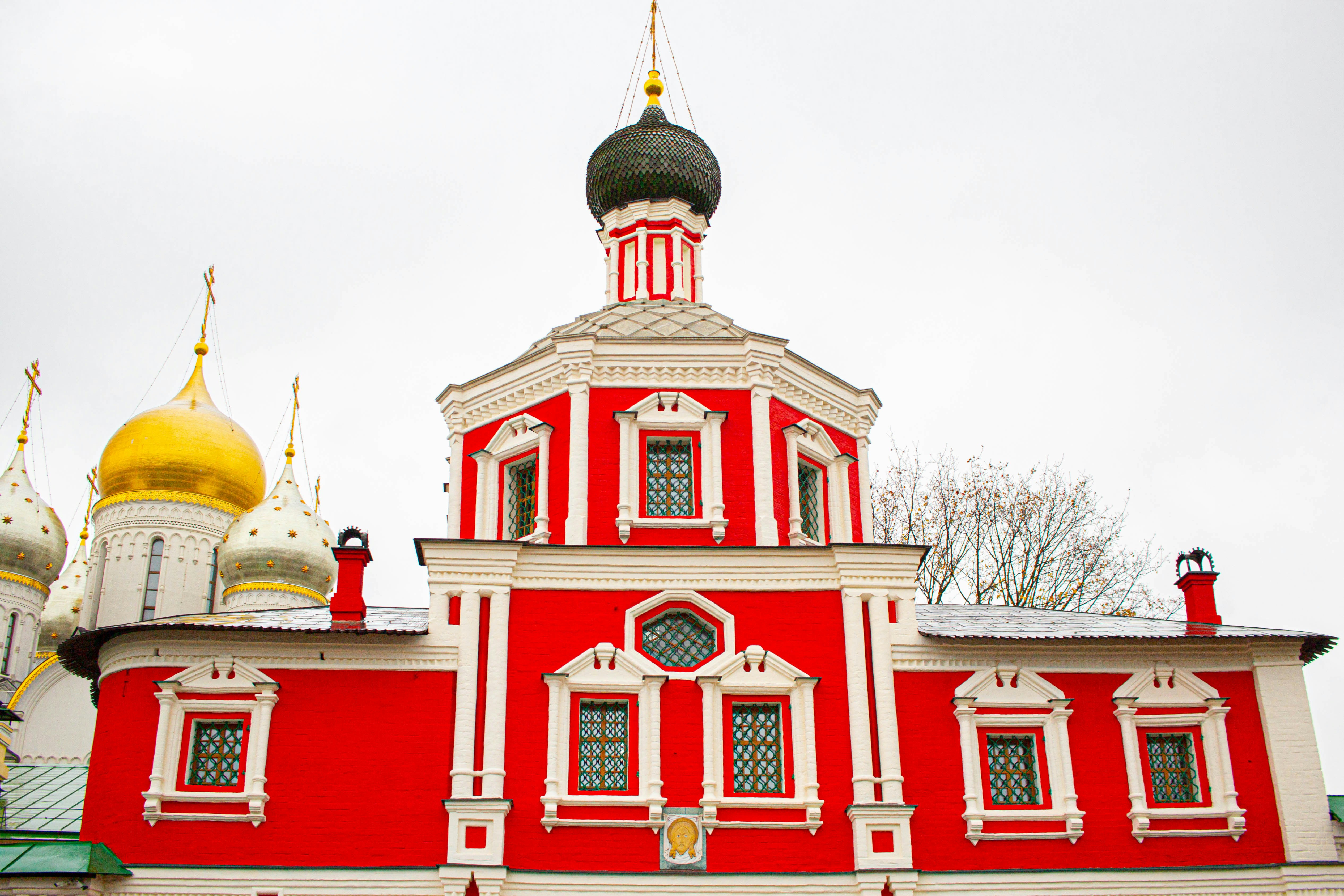 Royal Red Facade: A Russian Orthodox Church towers with gold domes