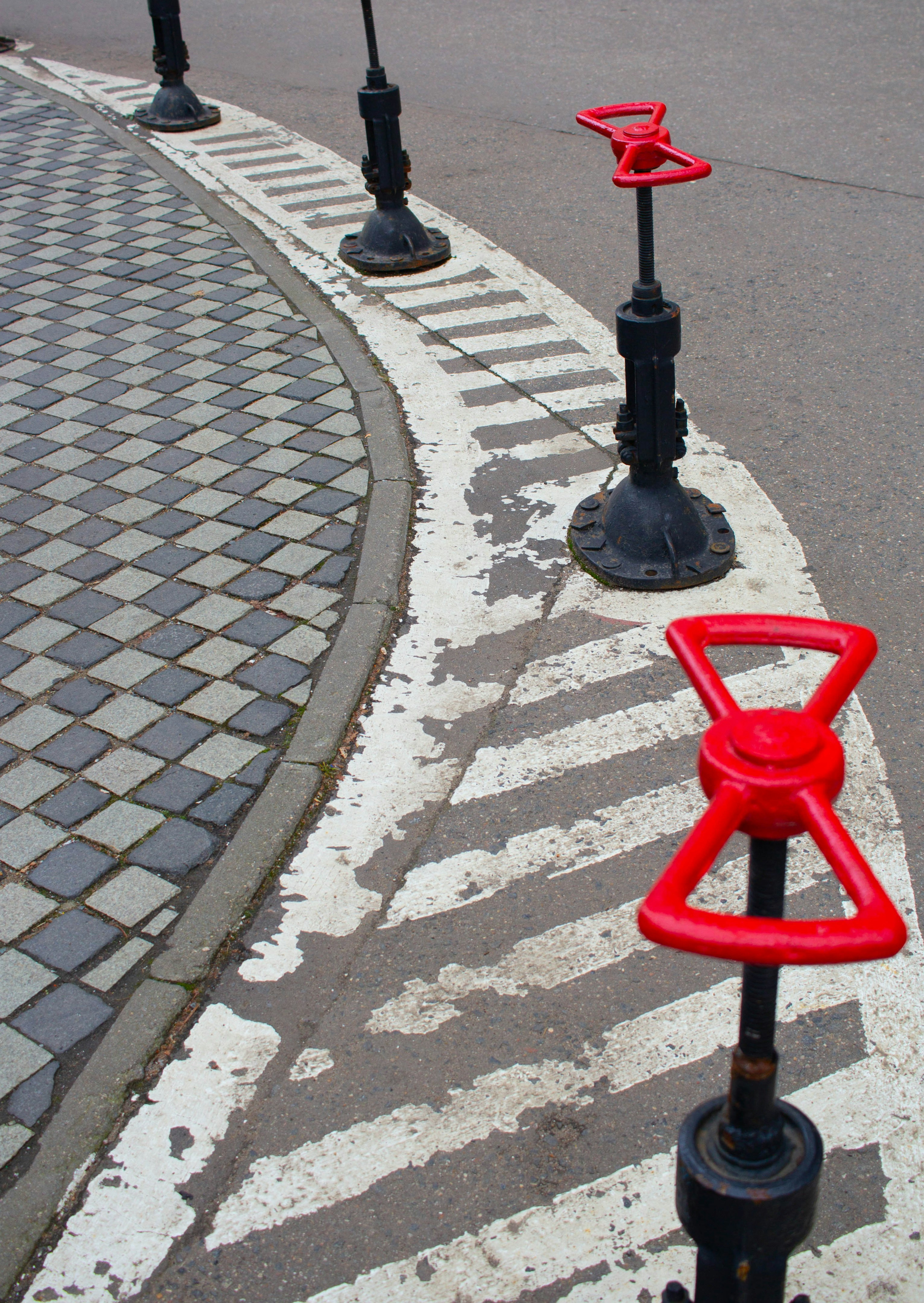 Red Handrails on a Curved Urban Curbstone